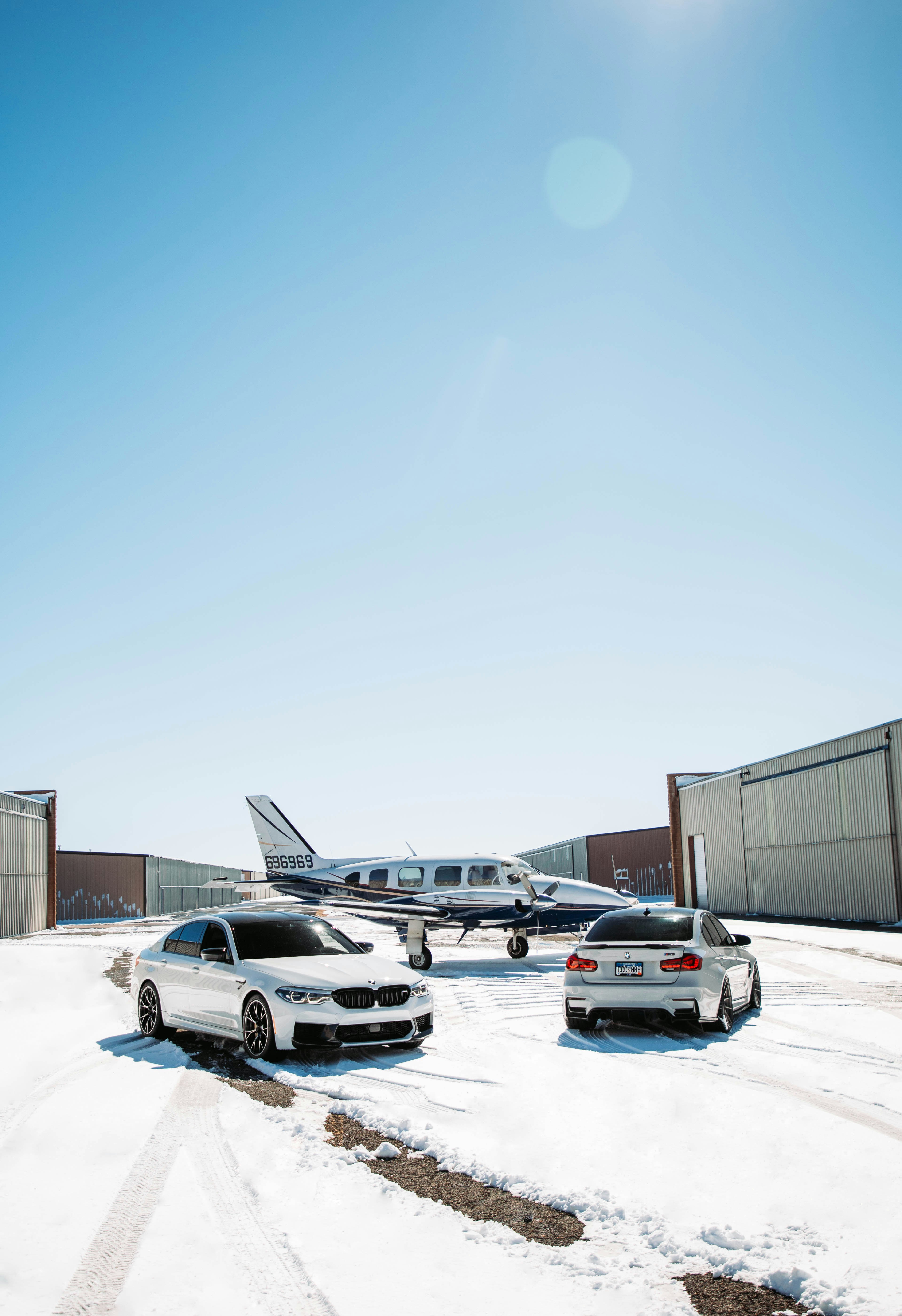Foto Dos autos estacionados frente a un avión en una pista nevada ...
