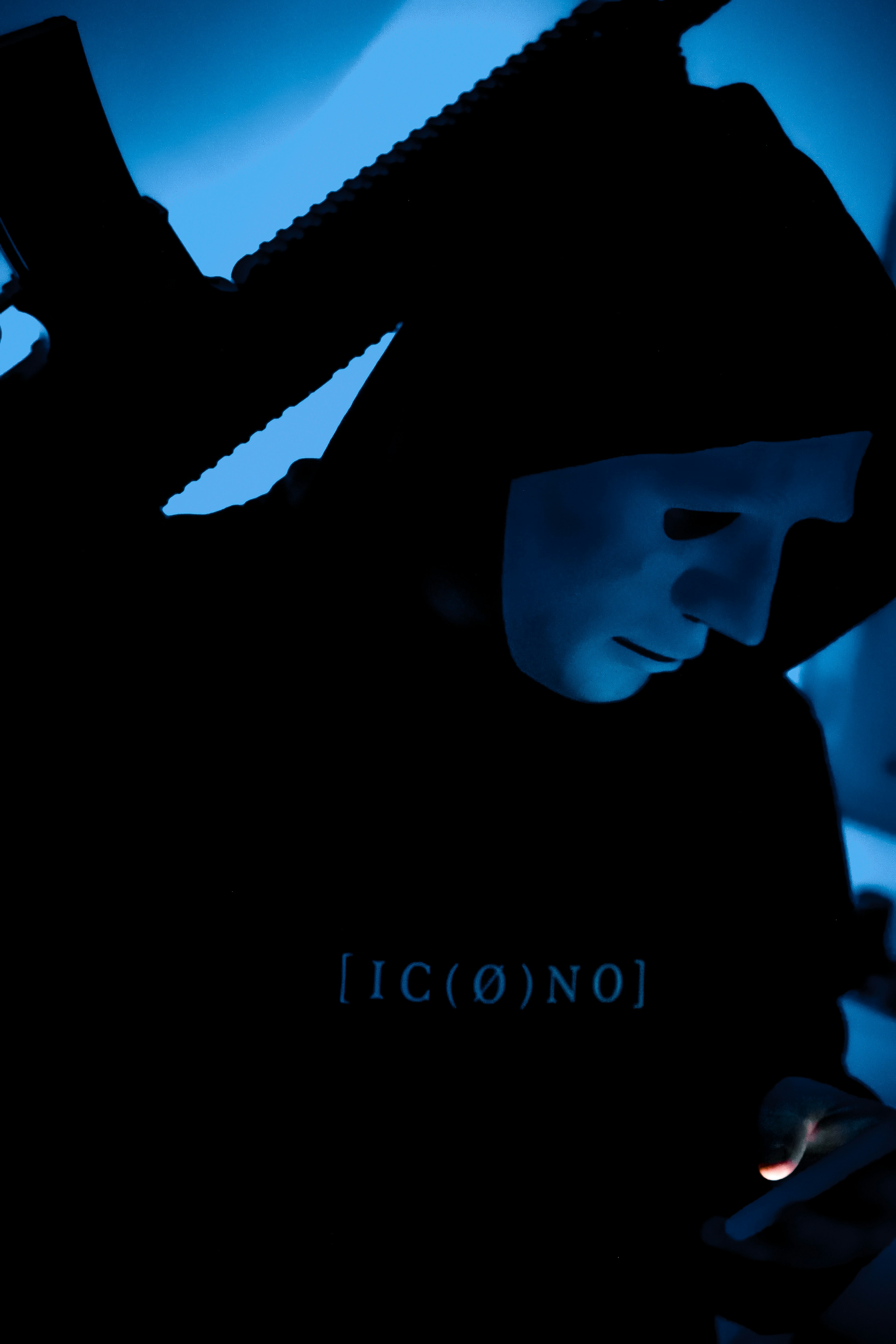 Blue-lit Reverie: A Hooded Figure in Neon Silence
