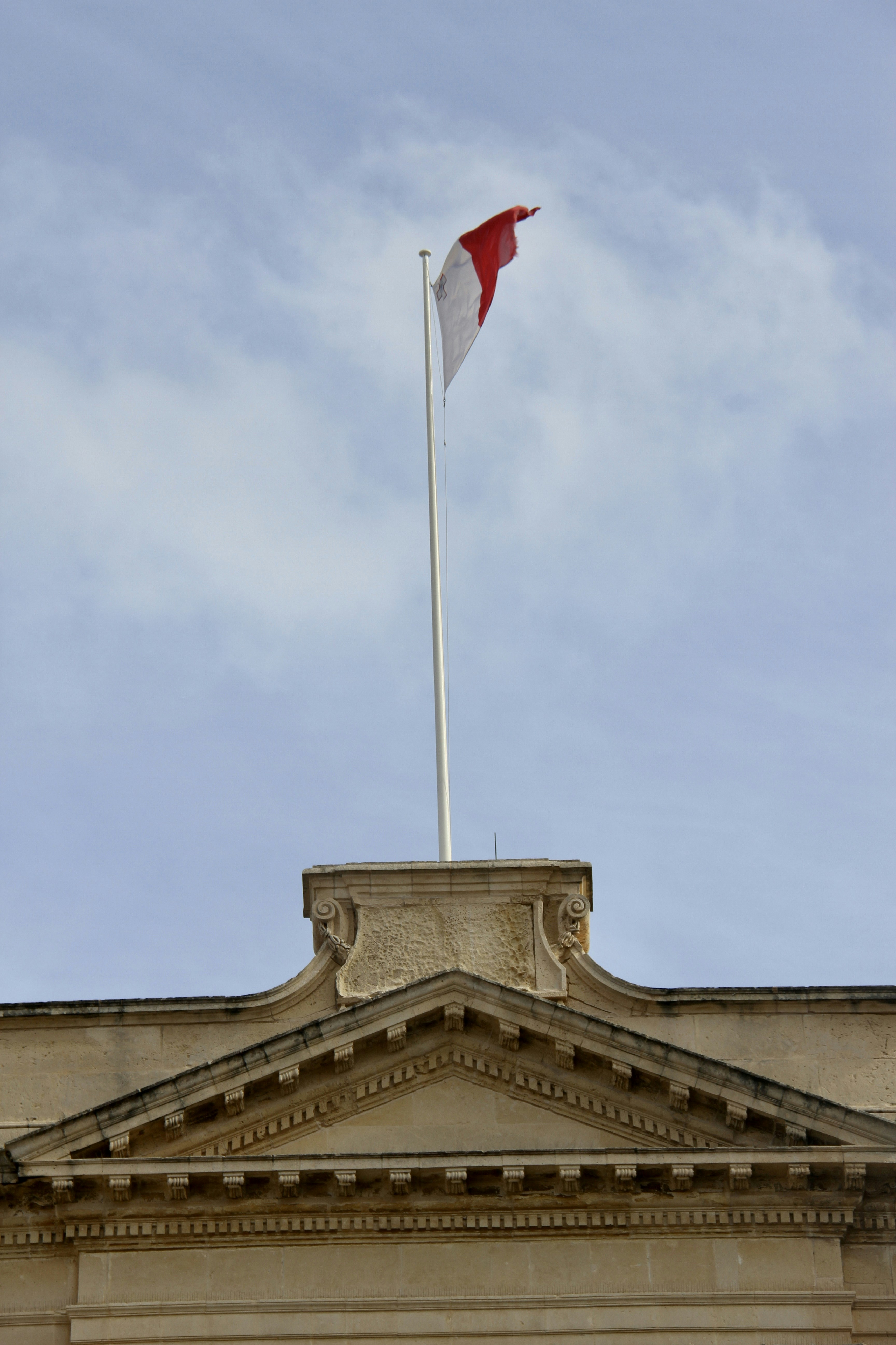 Flag at the Apex: A Neoclassical Pediment Crowned by a Wind-Brushed Banner
