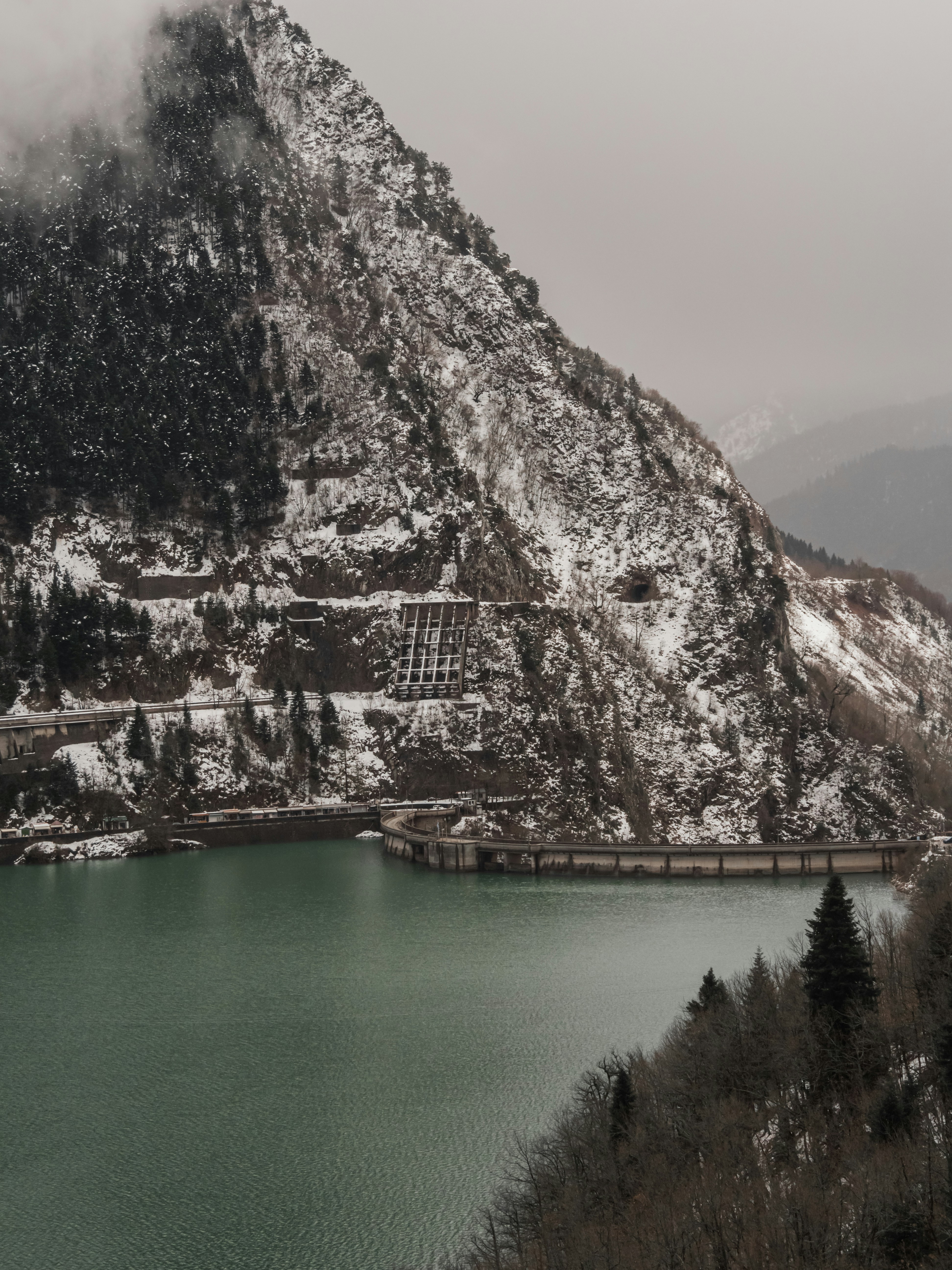 Granite Spine Over Green Waters: A Snowbound Reservoir Scene