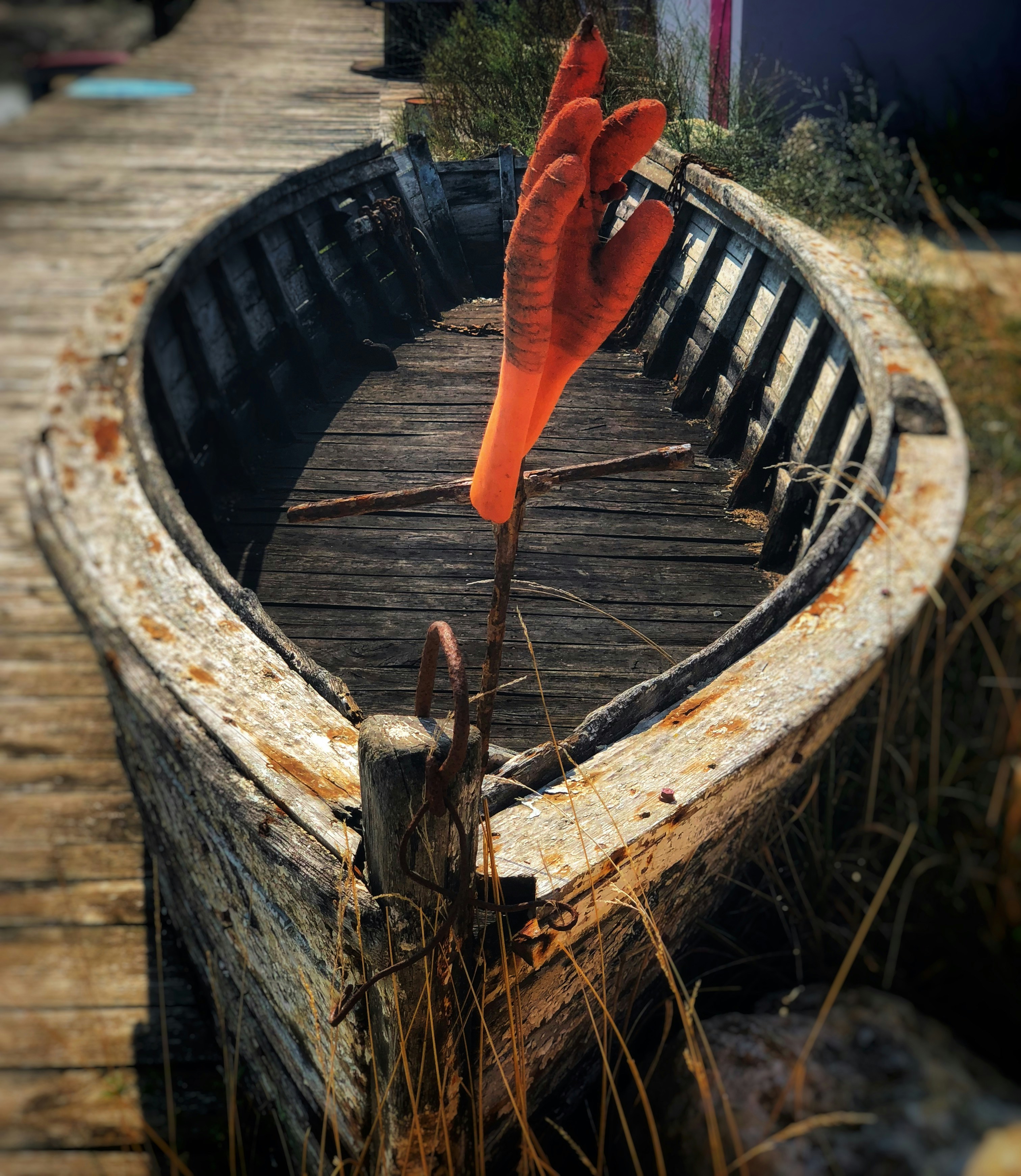 a rusted boat sitting on top of a wooden dock