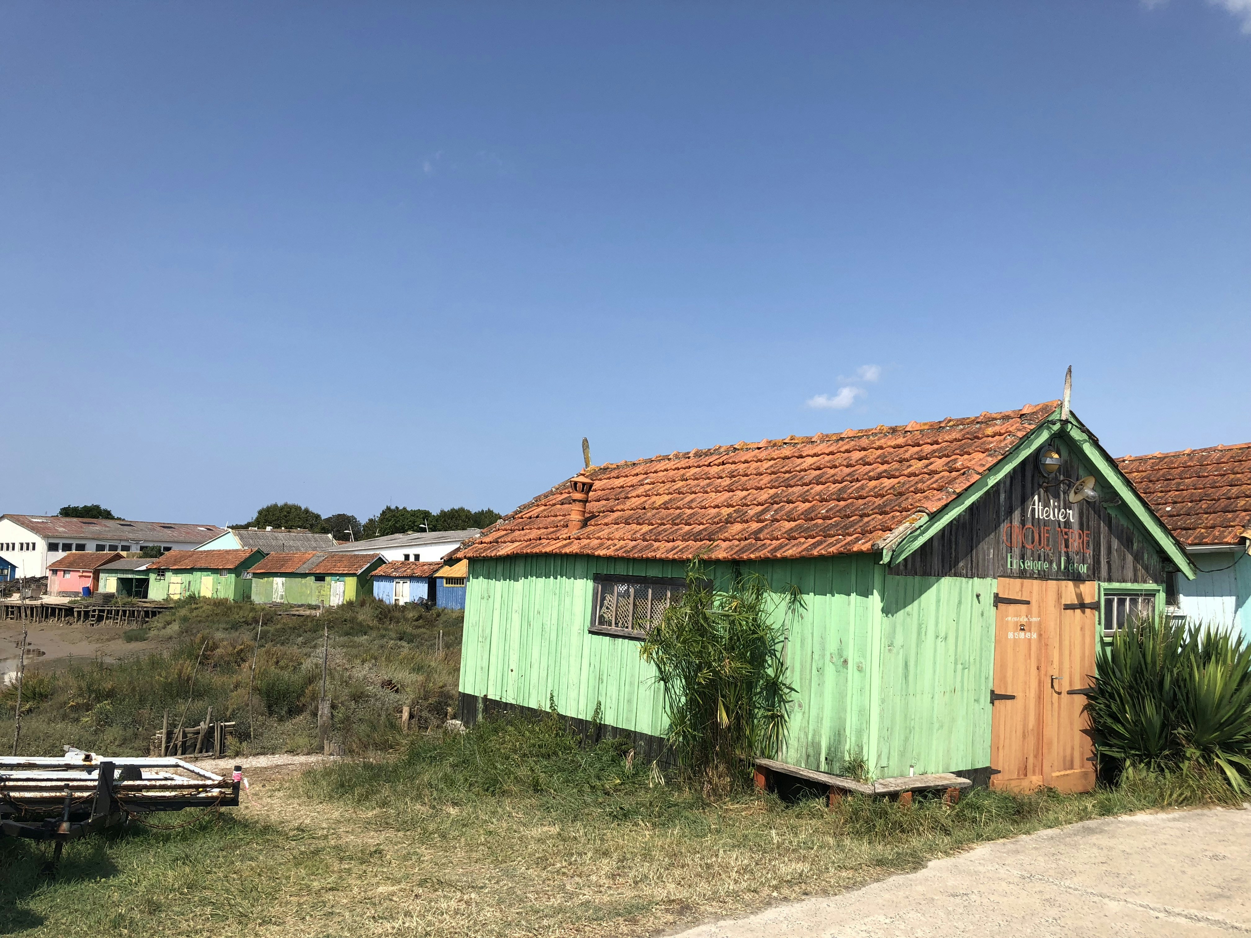 Colorful wooden shanties line the coast, showcasing a blend of nature and craftsmanship. The scene captures the essence of coastal living.