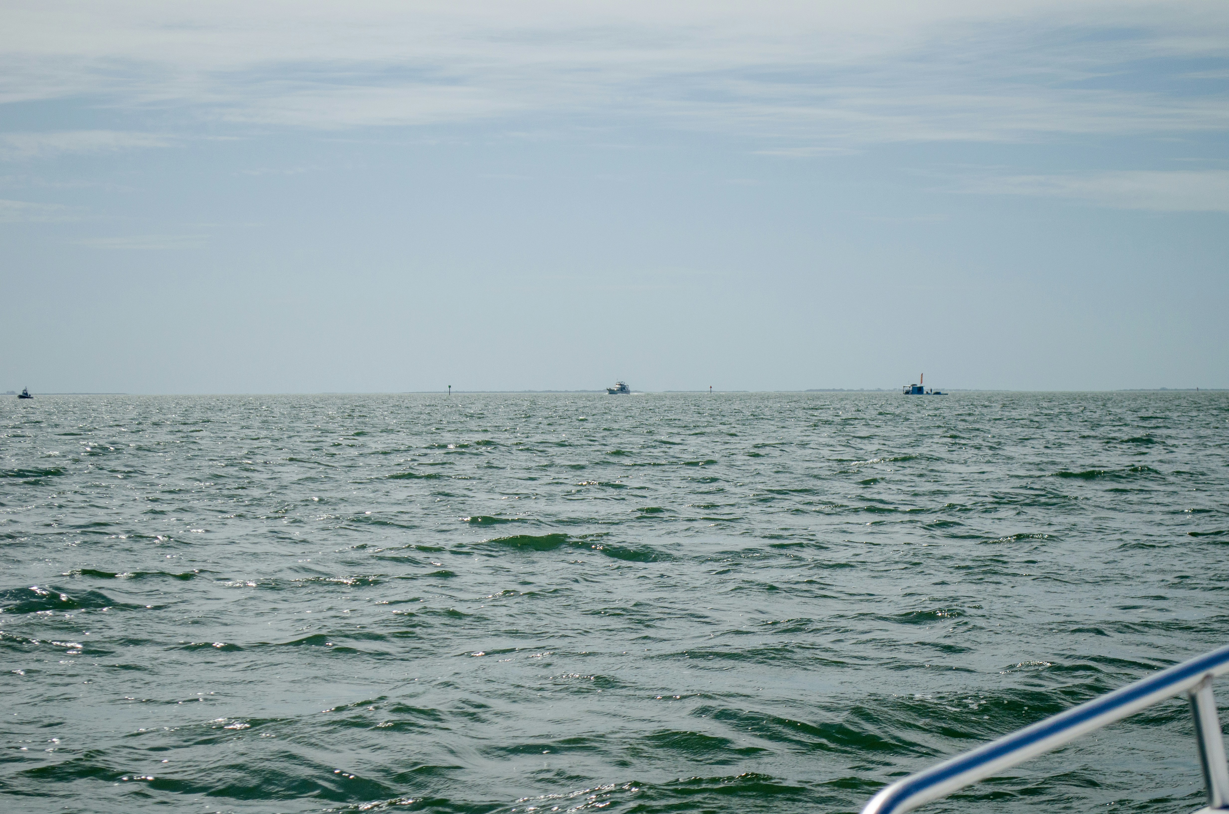 A body of water with boats in the distance photo – Free Boating Image ...