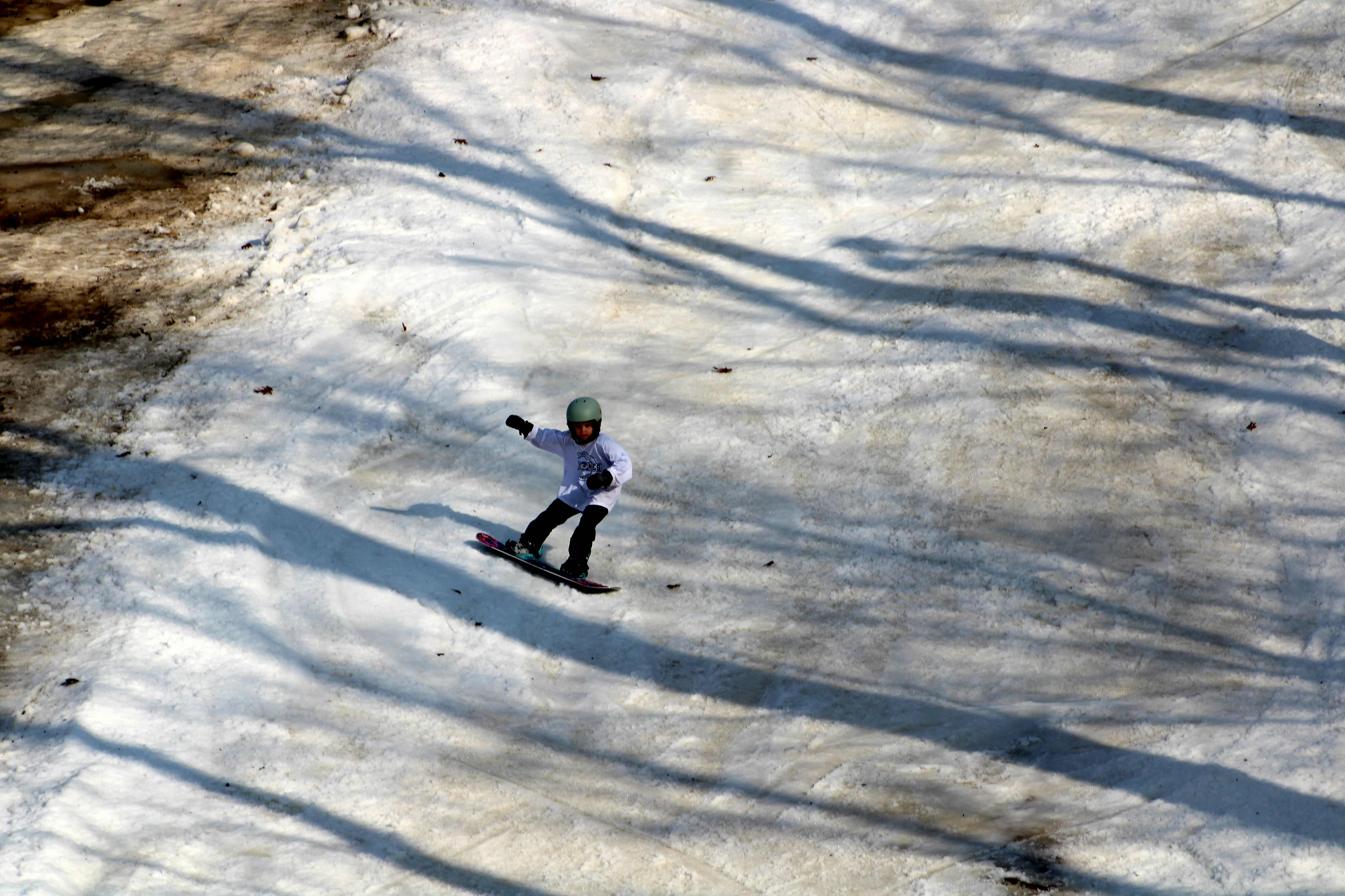 a man riding a snowboard down a snow covered slope