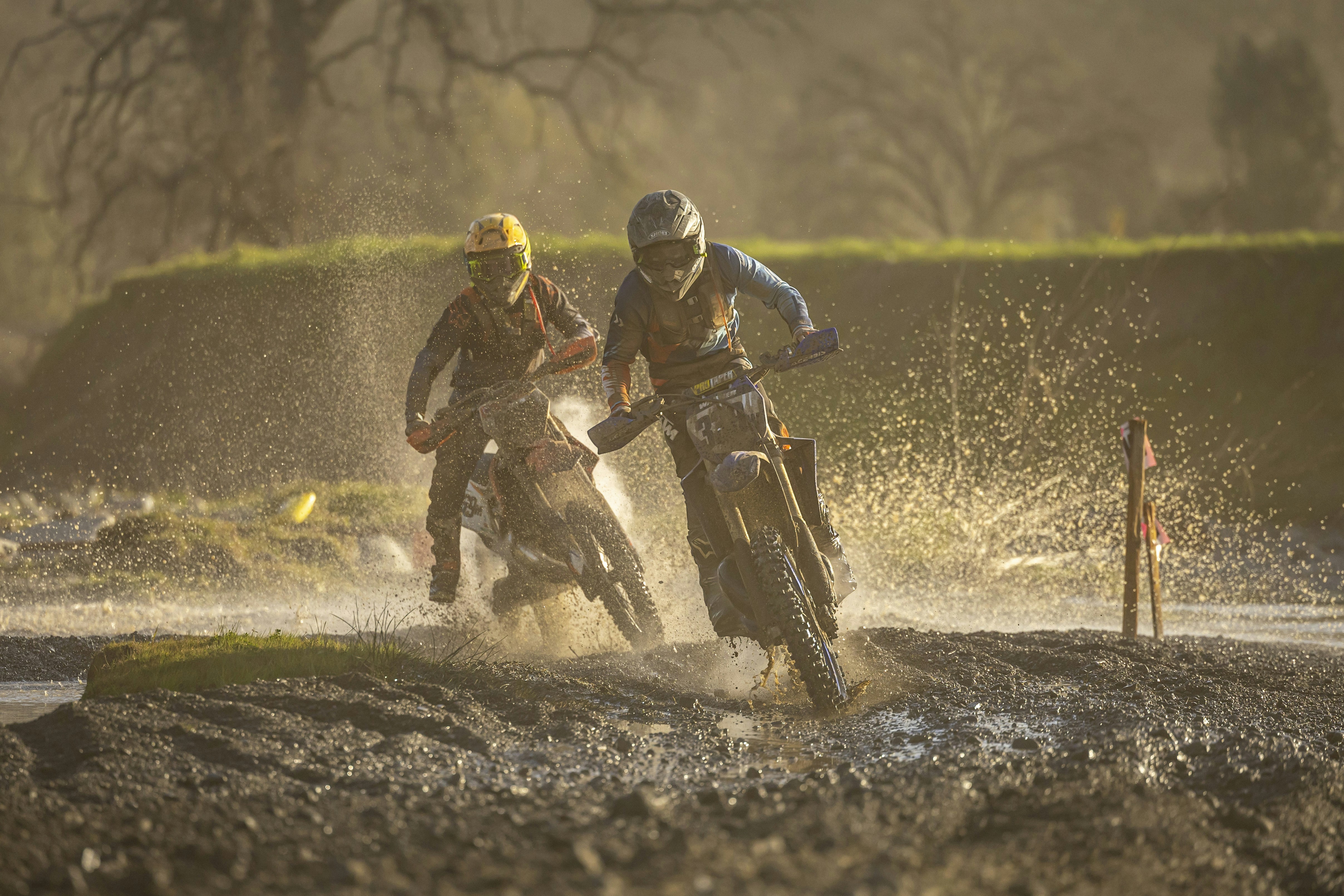 Foto Un par de personas montadas en la parte trasera de motos de cross ...