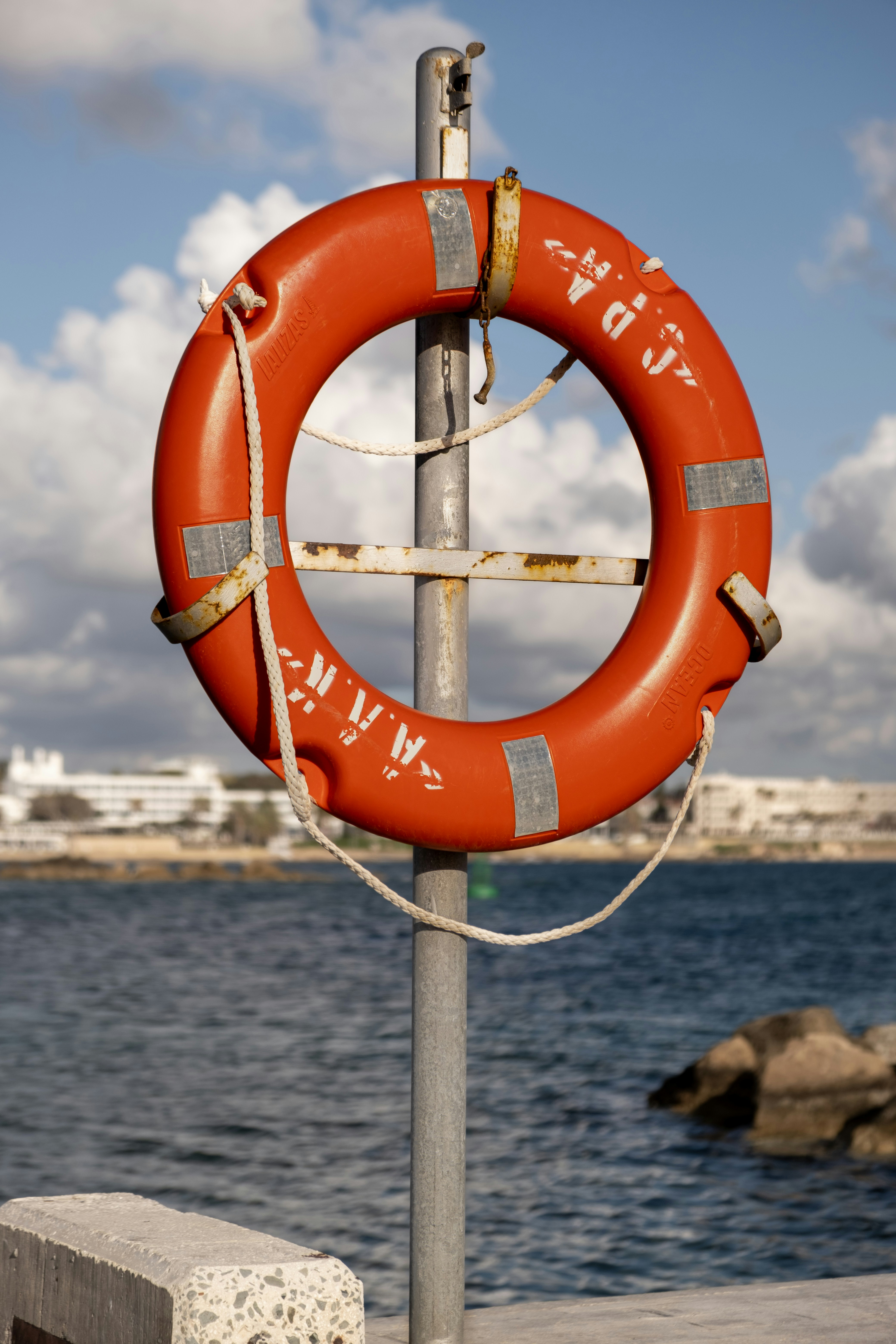 A life preserver on a pole near a body of water photo – Free Coastal ...