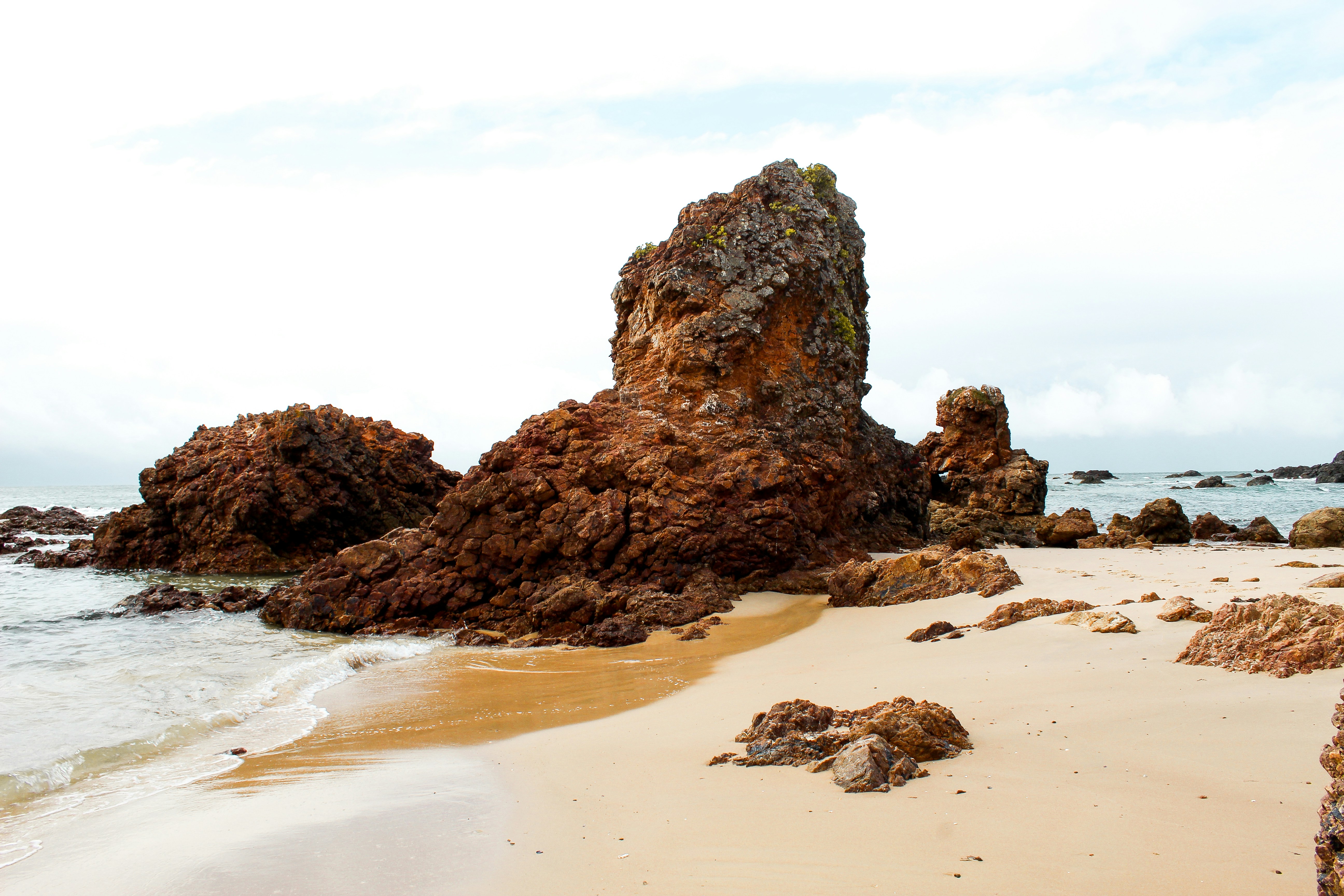 Foto Una formación rocosa en una playa de arena junto al océano ...