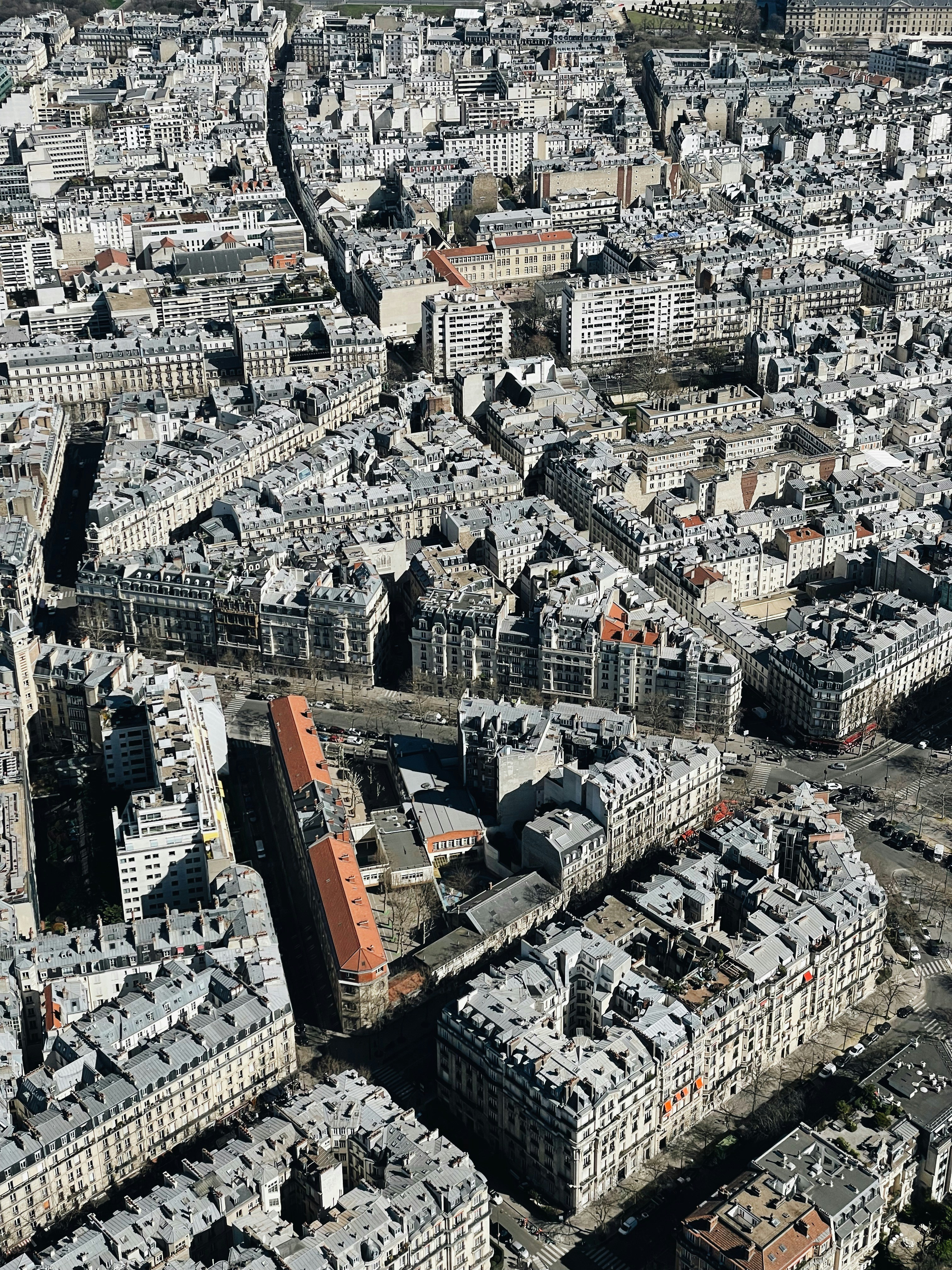 Aerial view showcasing the intricate patterns of urban architecture and streets in a densely populated city. The layout highlights a mix of residential and commercial buildings.