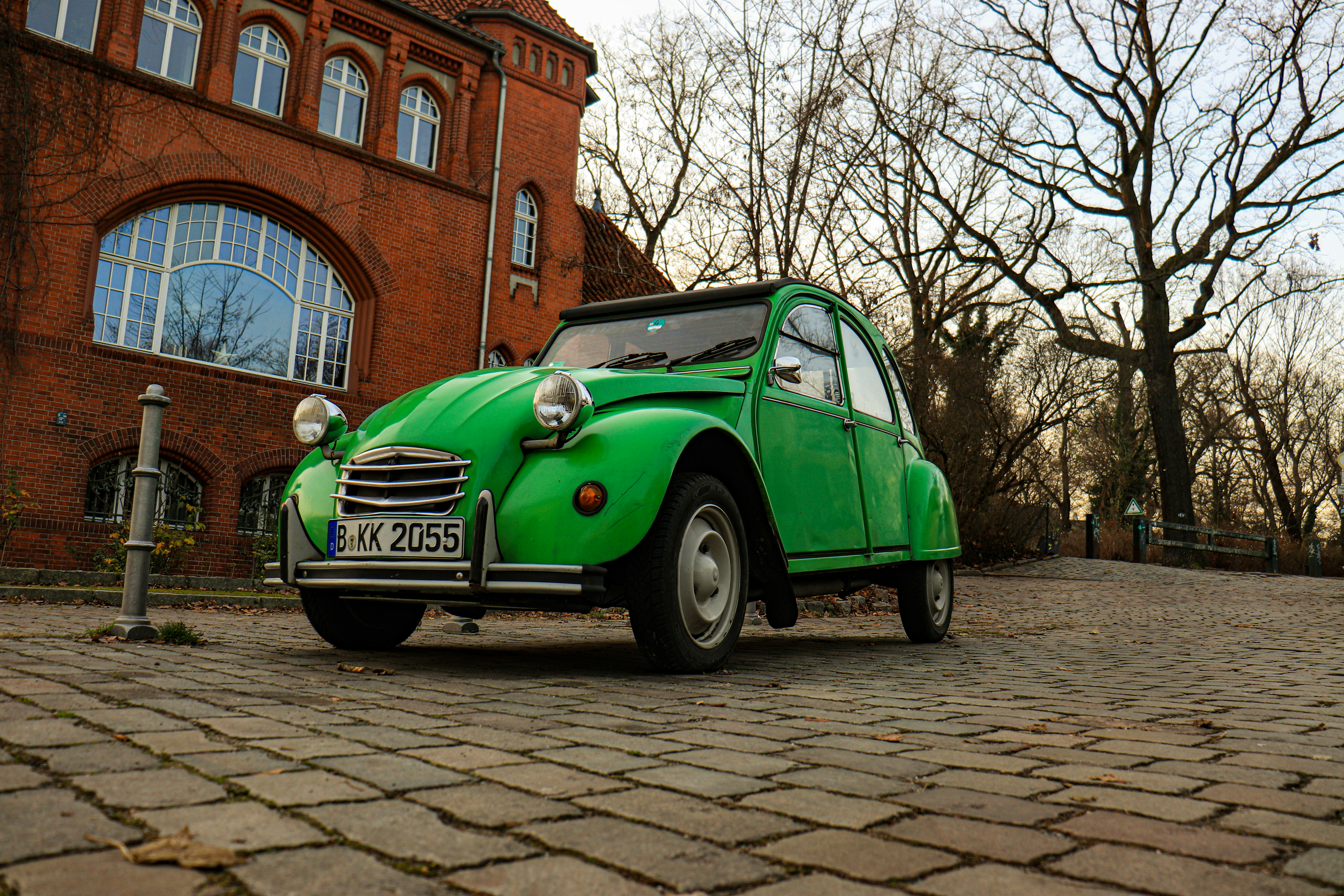 Un'auto verde parcheggiata di fronte a un edificio di mattoni foto ...