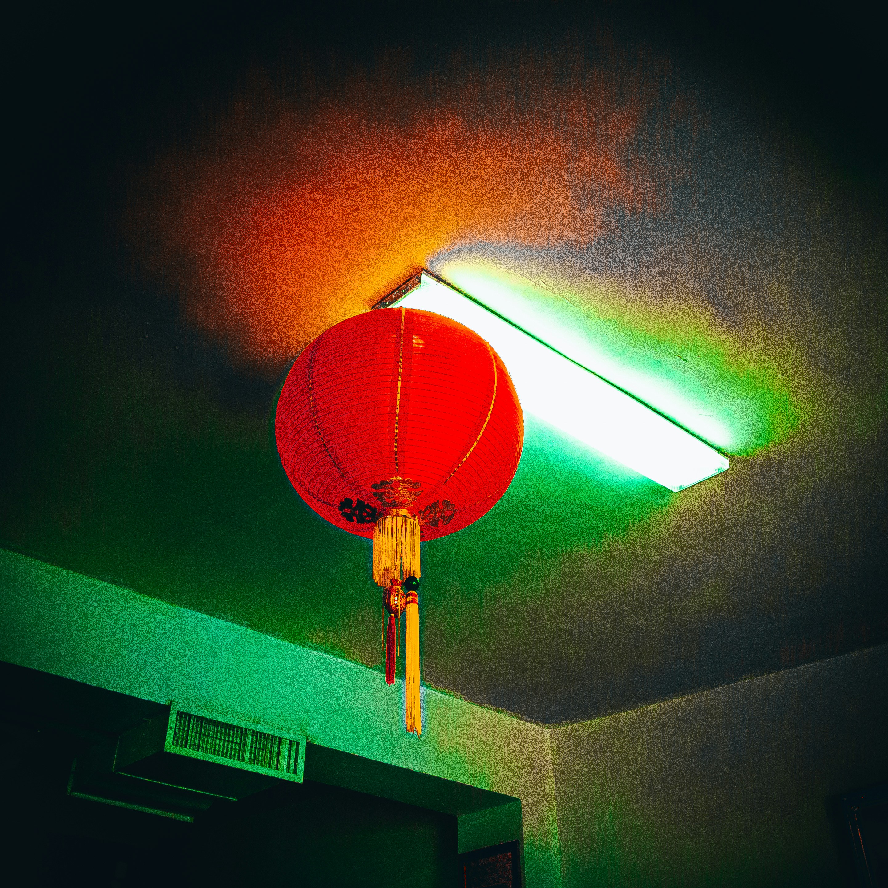 a red lamp hanging from a ceiling in a room