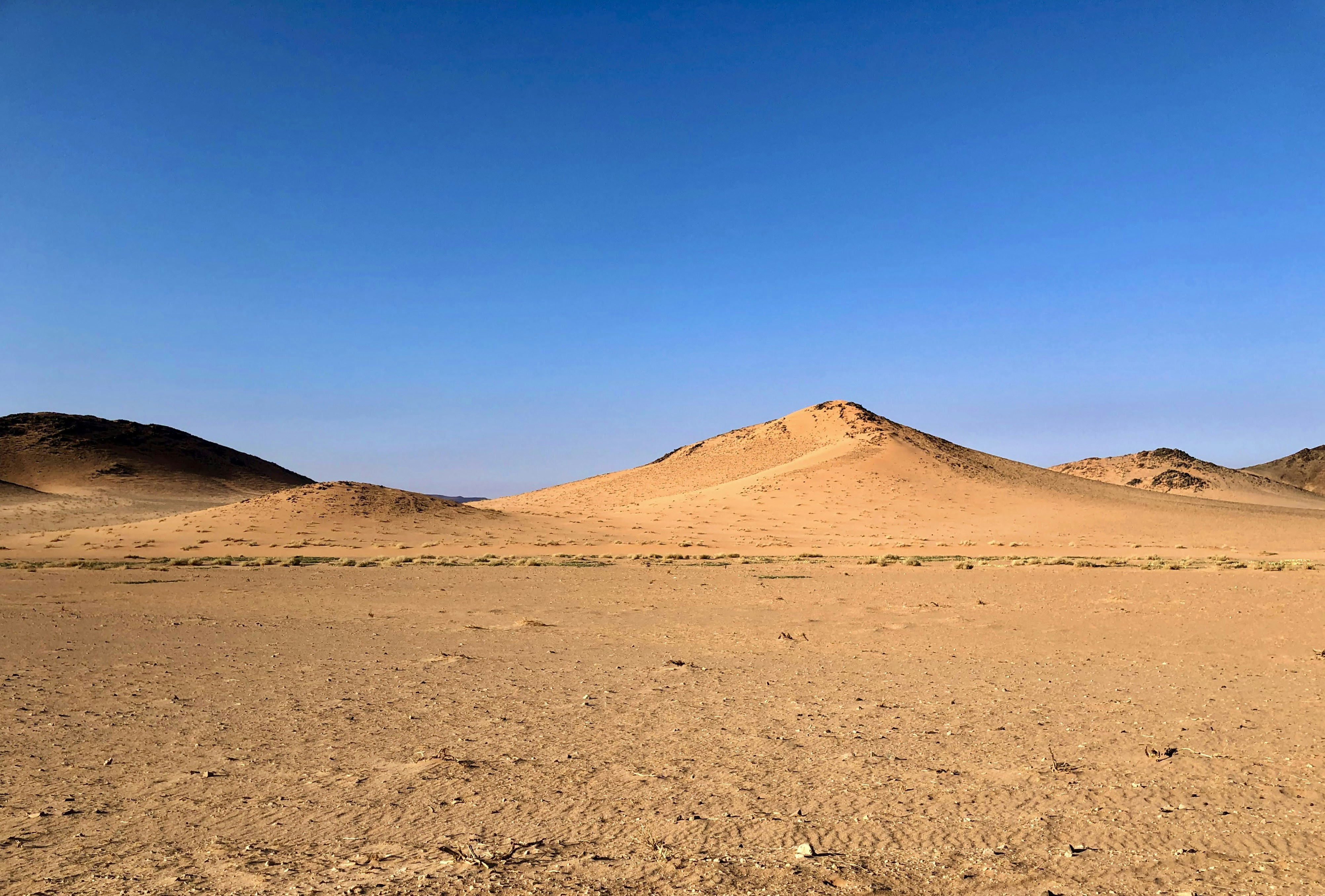 Un paysage désertique avec quelques collines au loin photo – Photo Bleu ...