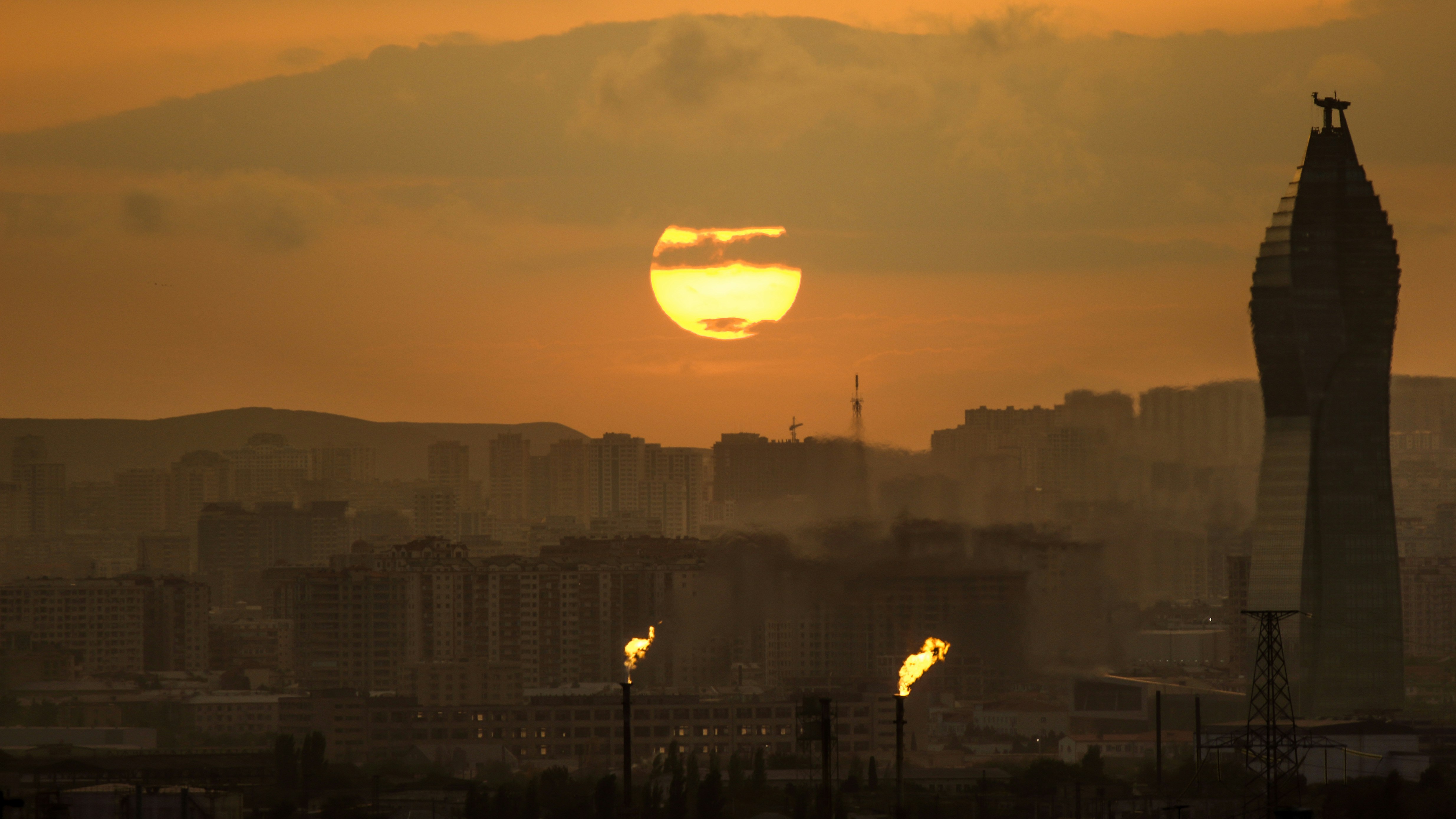 Dusk Ember Between Towers: The Sun Drapes a Curved Skyline