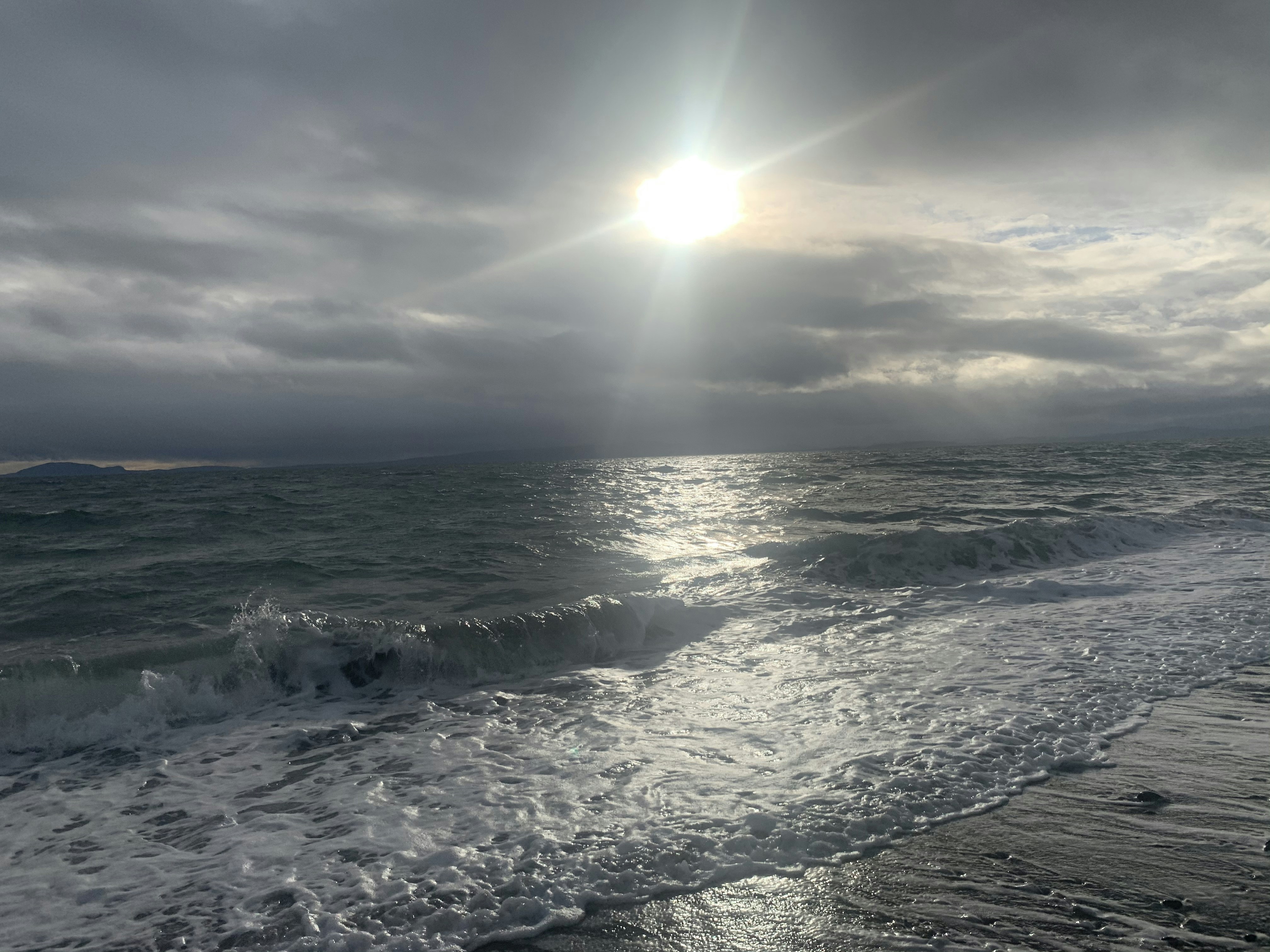 The sun shining through the clouds over the ocean photo – Free Wa Image ...