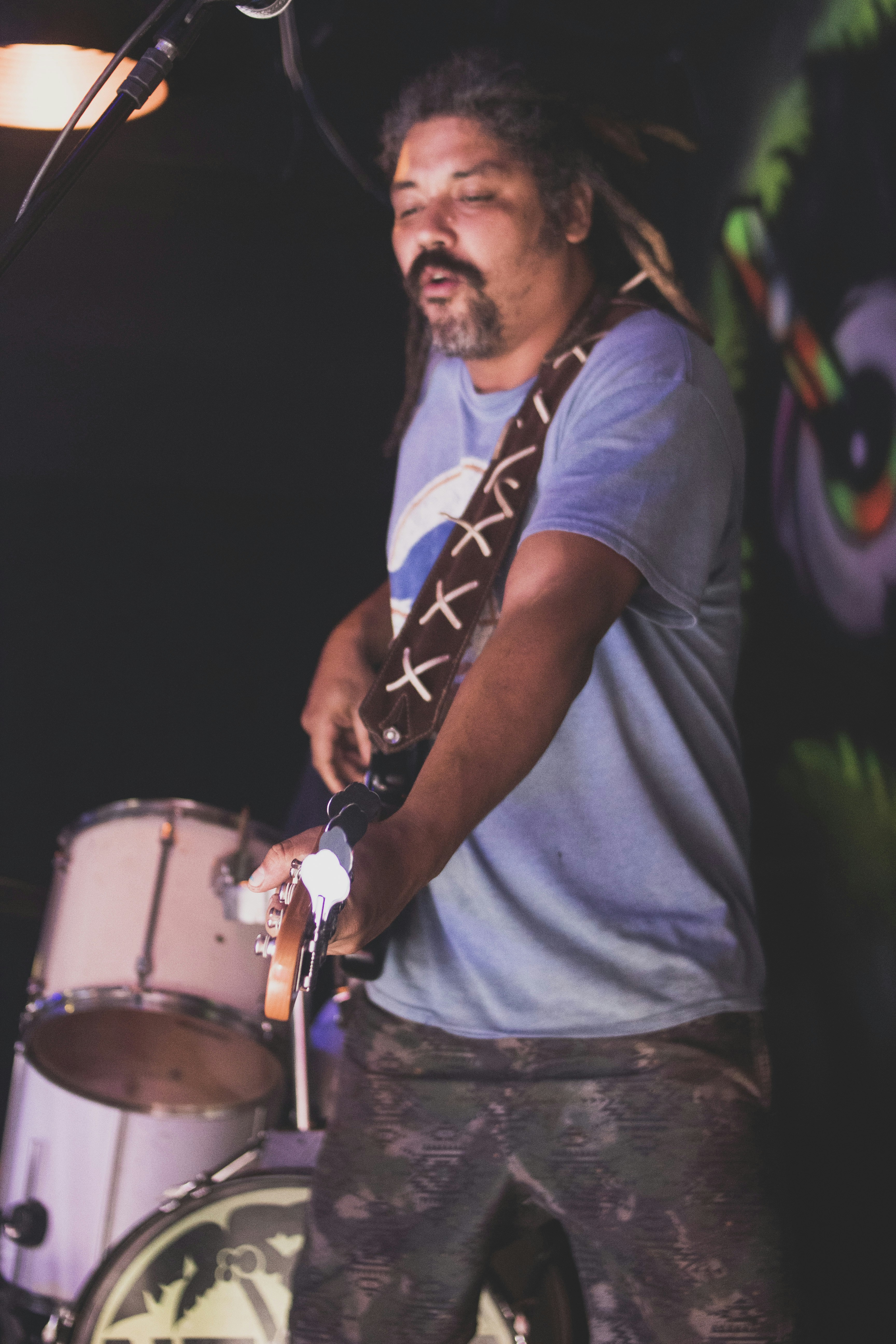 Graffiti-Groove Under Dim Stage Lights: guitarist in mural backdrop