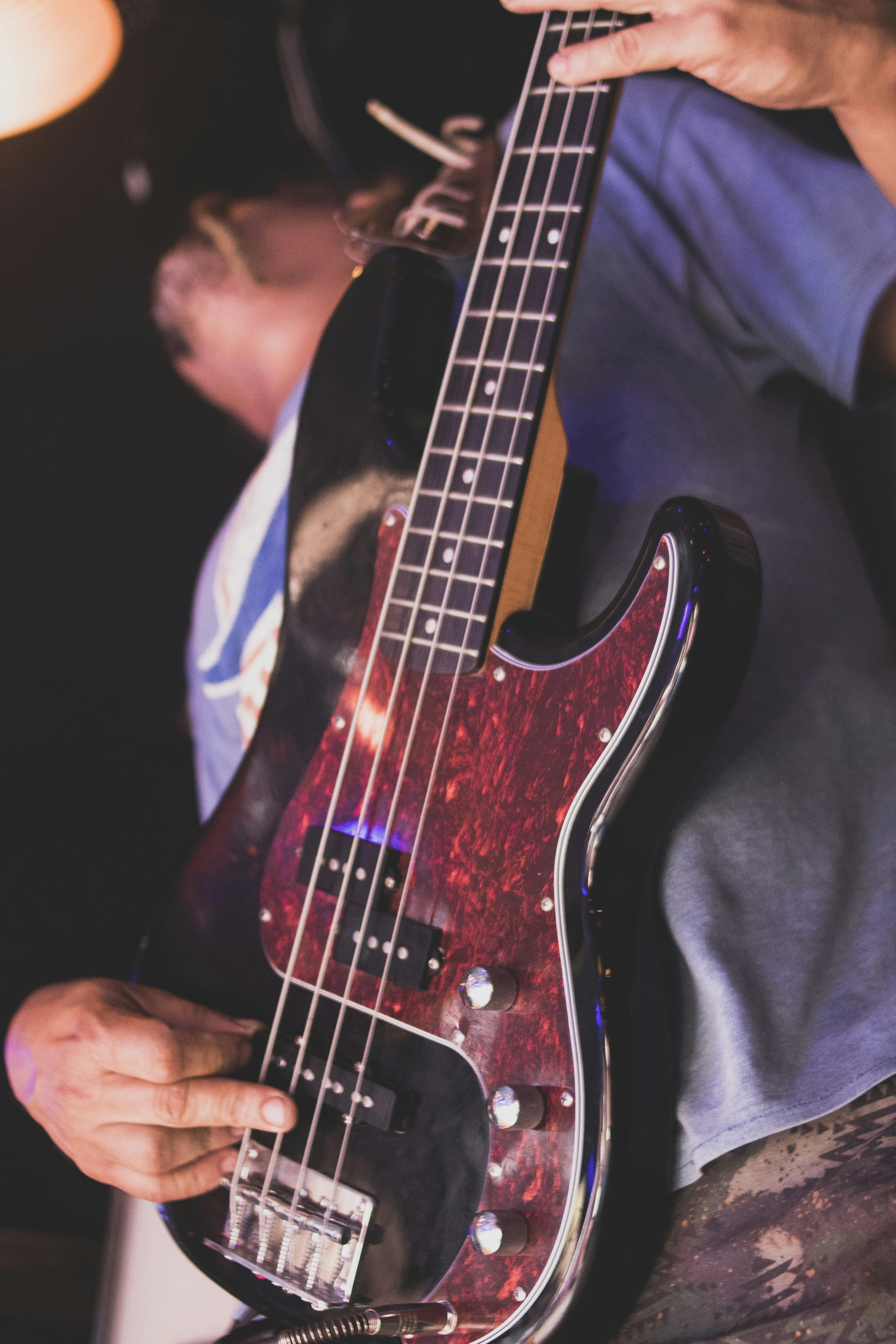 Close-up of a bassist passionately playing an electric bass guitar on stage, capturing the essence of live music performance.