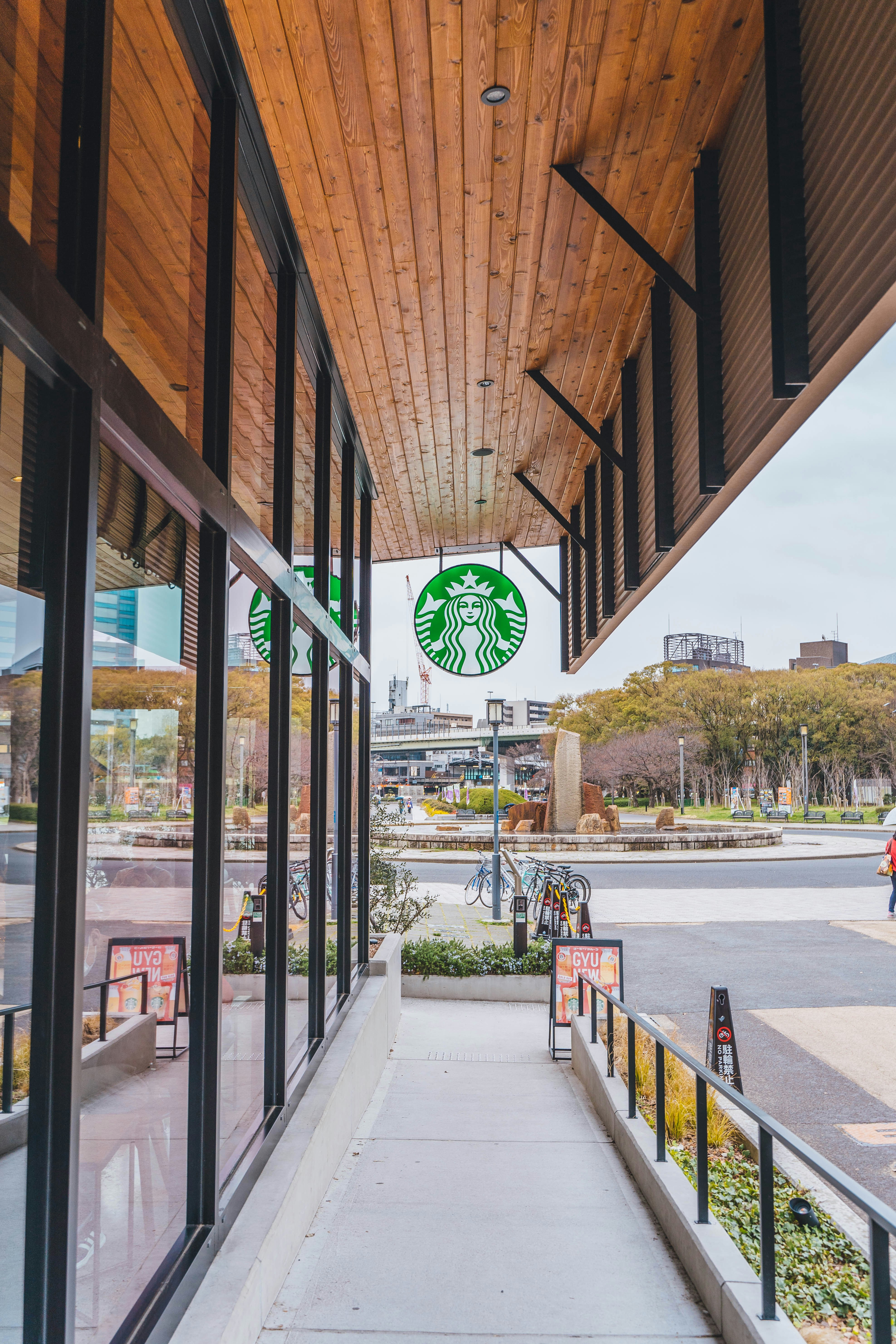 A starbucks sign hanging from the side of a building photo – Free Osaka ...