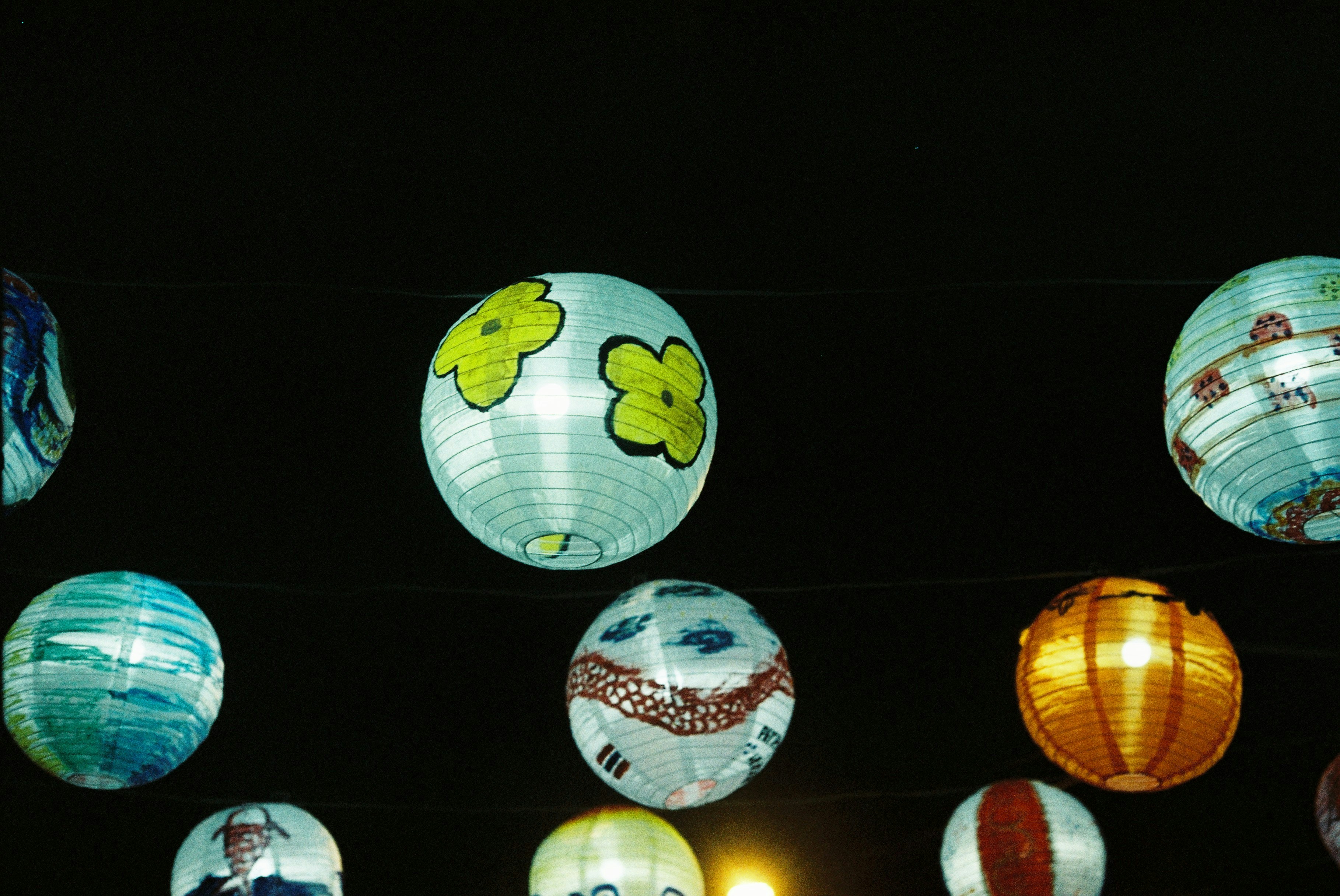 Colorful paper lanterns suspended against a night sky.