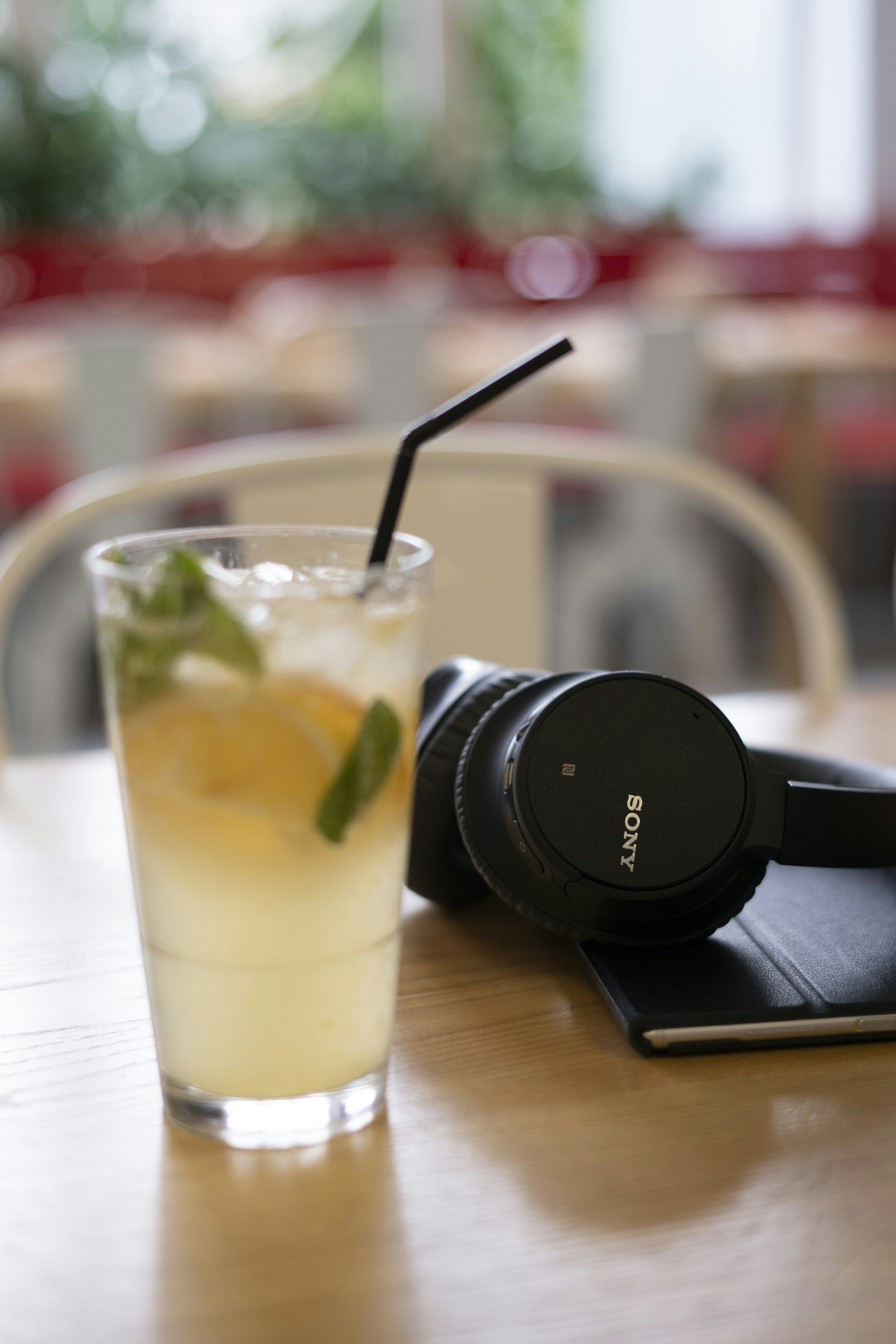 Sunlit Café Moment: Mint-Lemonade and Headphones on a Wooden Table