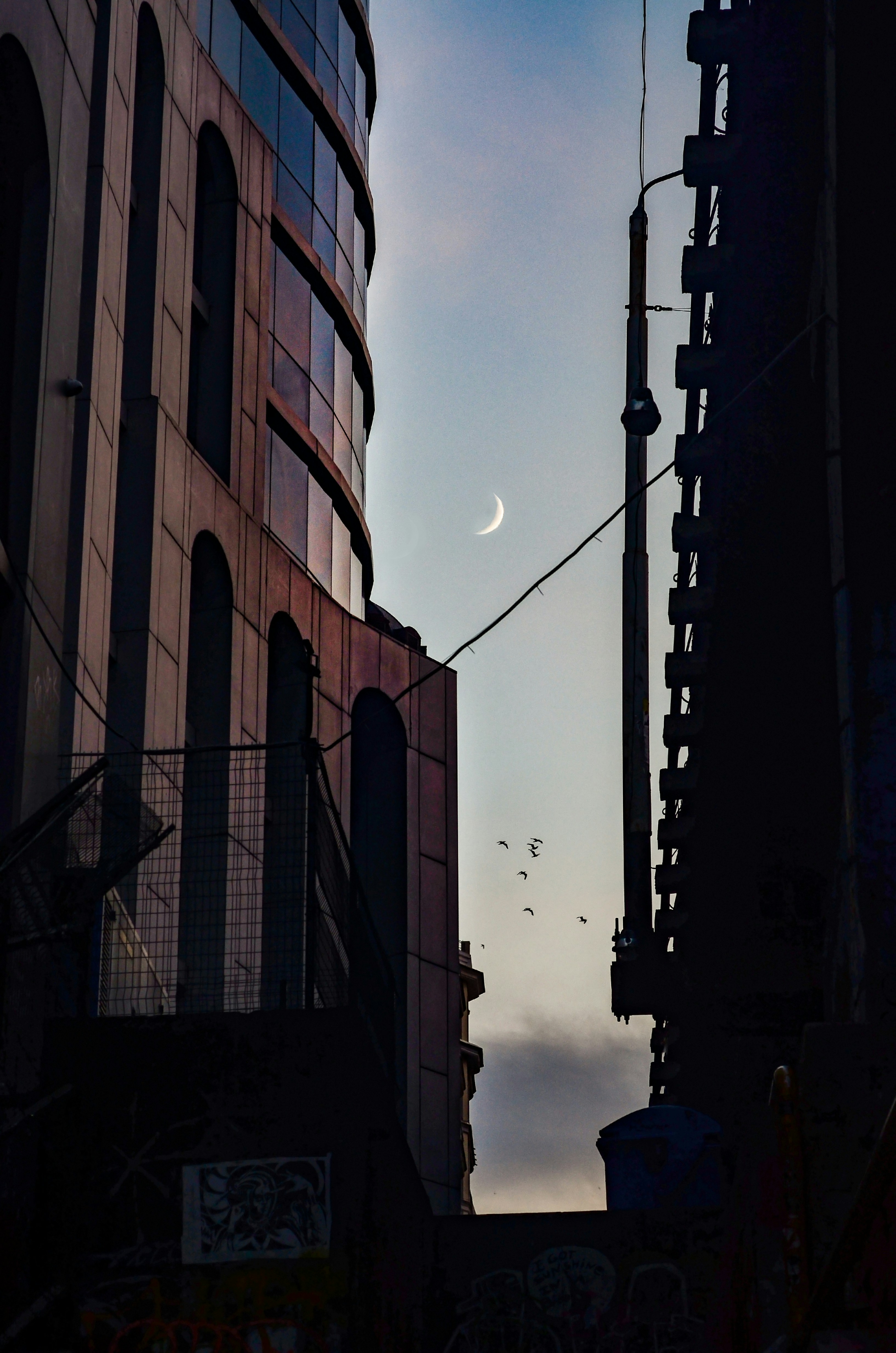 A view of a street with a half moon in the sky photo – Free Moon Image ...