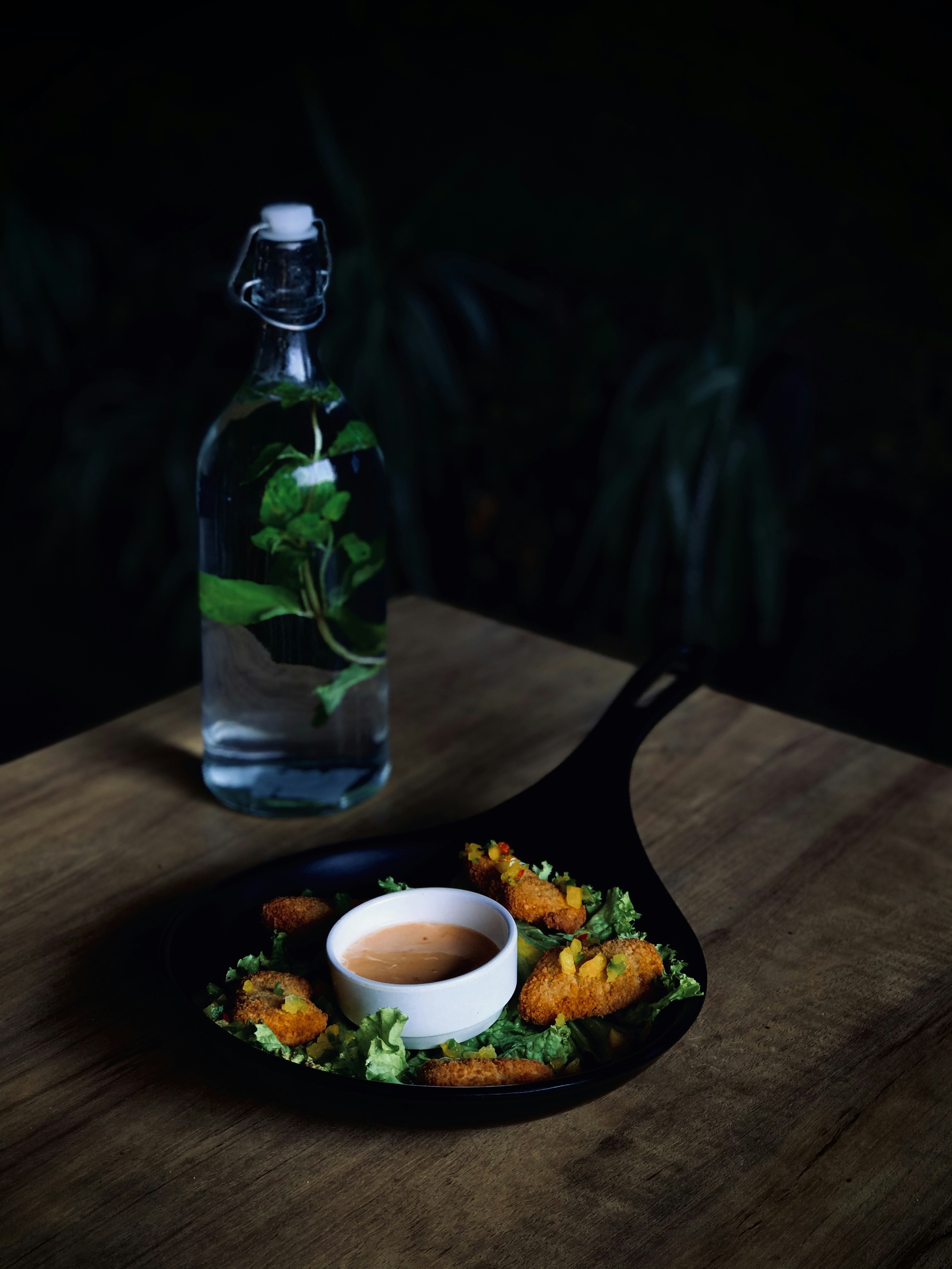 Moonlit Spoon Feast: Crispy Bites and Minted Water on a Wooden Table