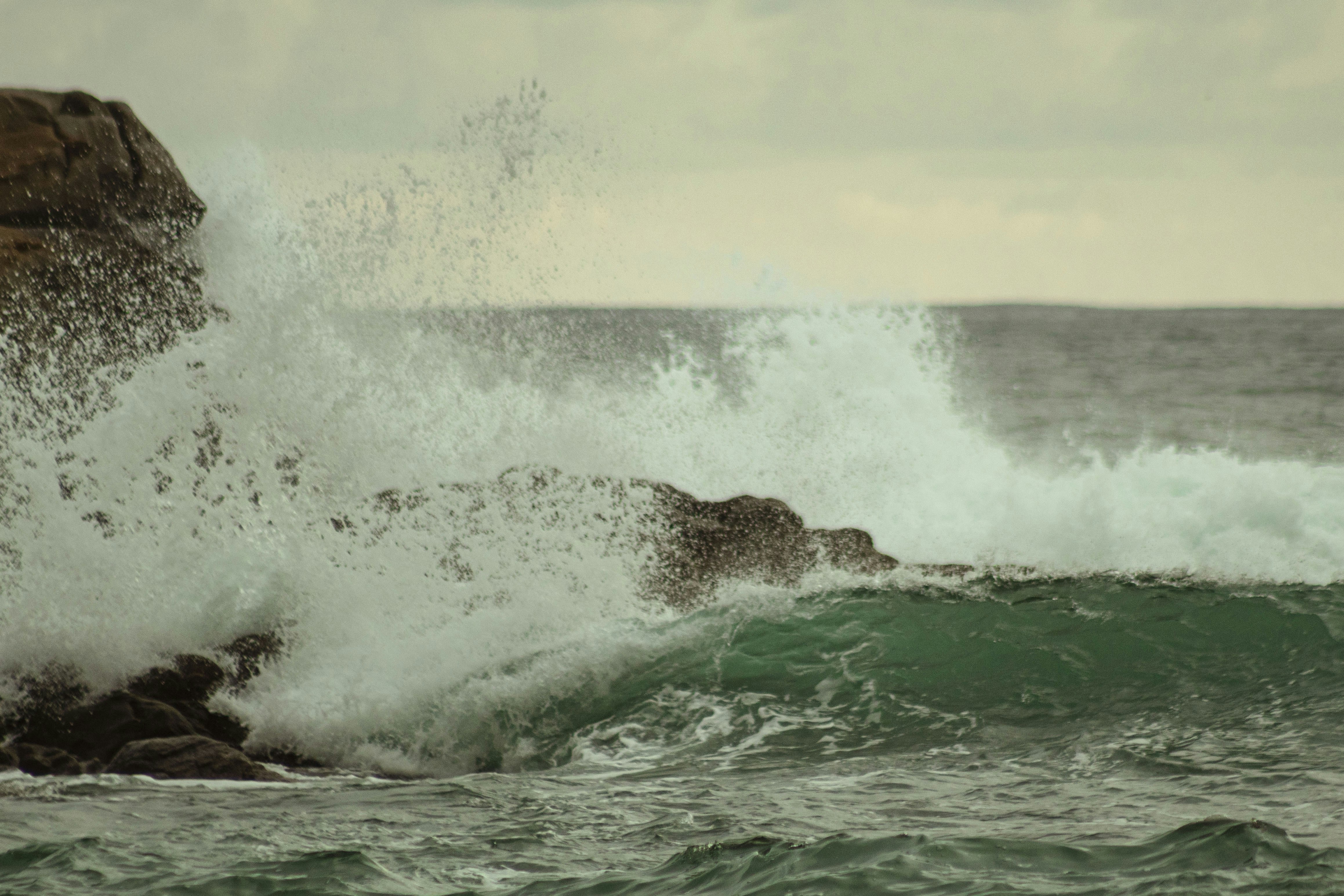 A wave crashes against a rock in the ocean photo – Free Carrizalillo ...