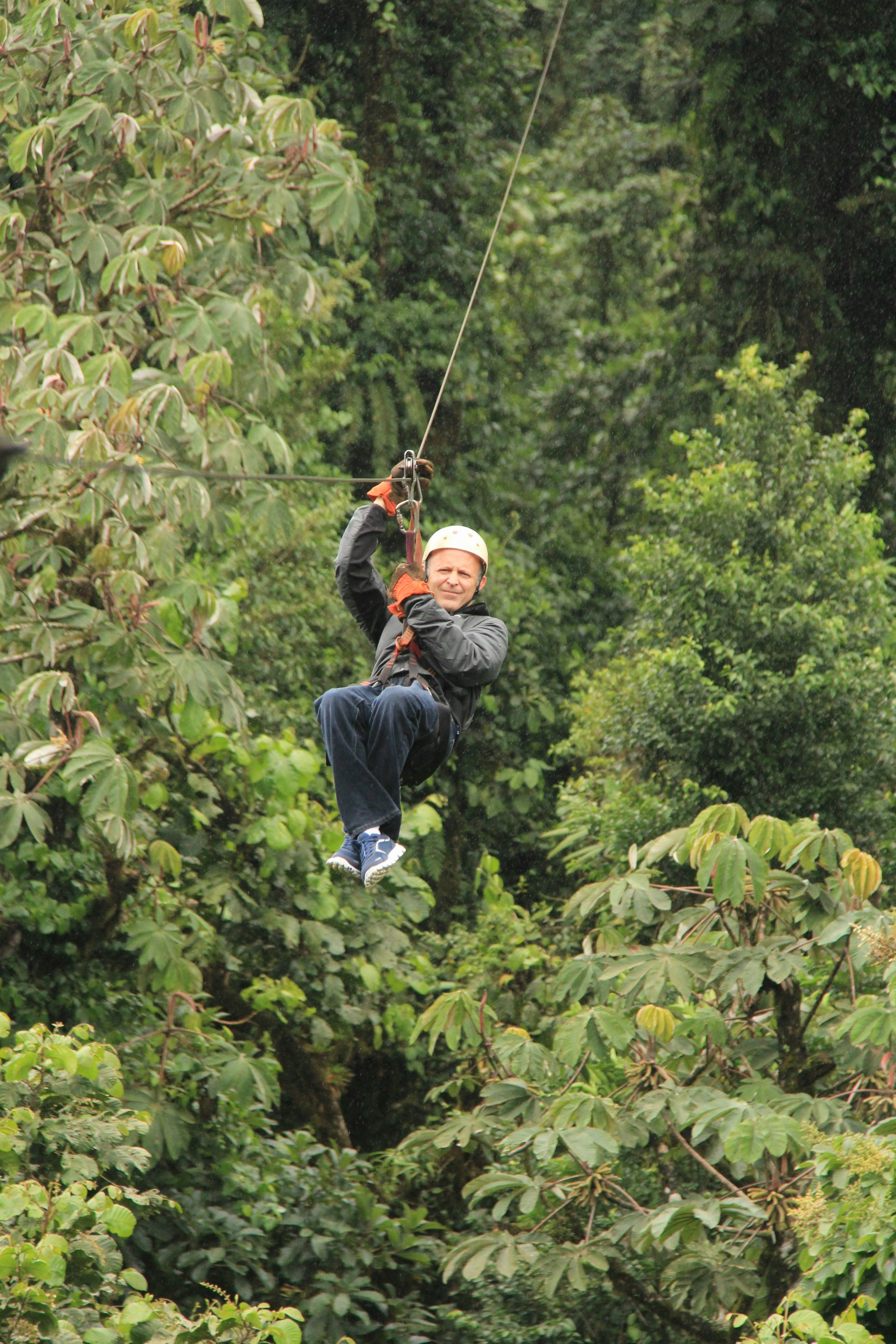 A man riding a zip line through a forest photo – Free Costa rica Image ...