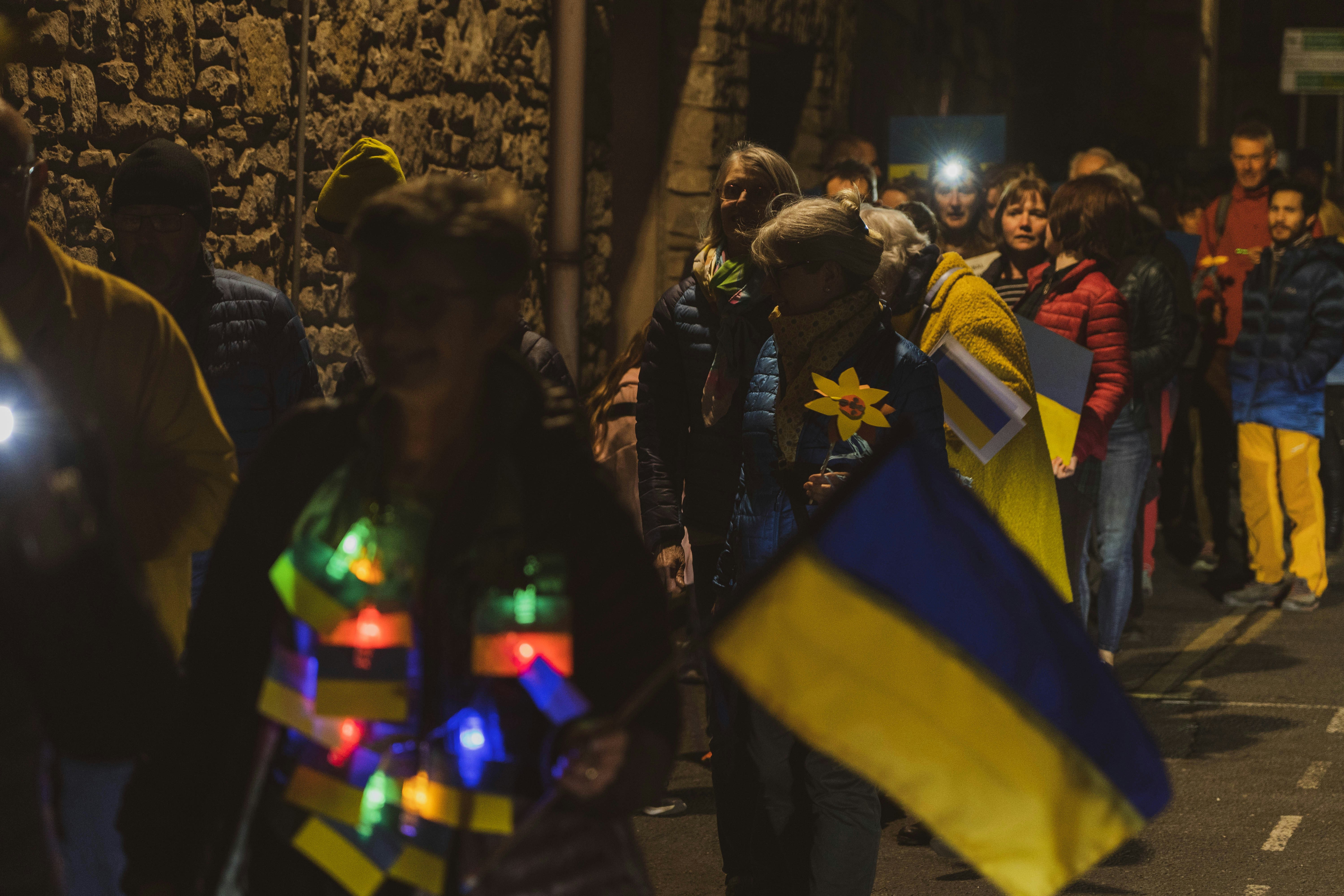 a group of people walking down a street at night