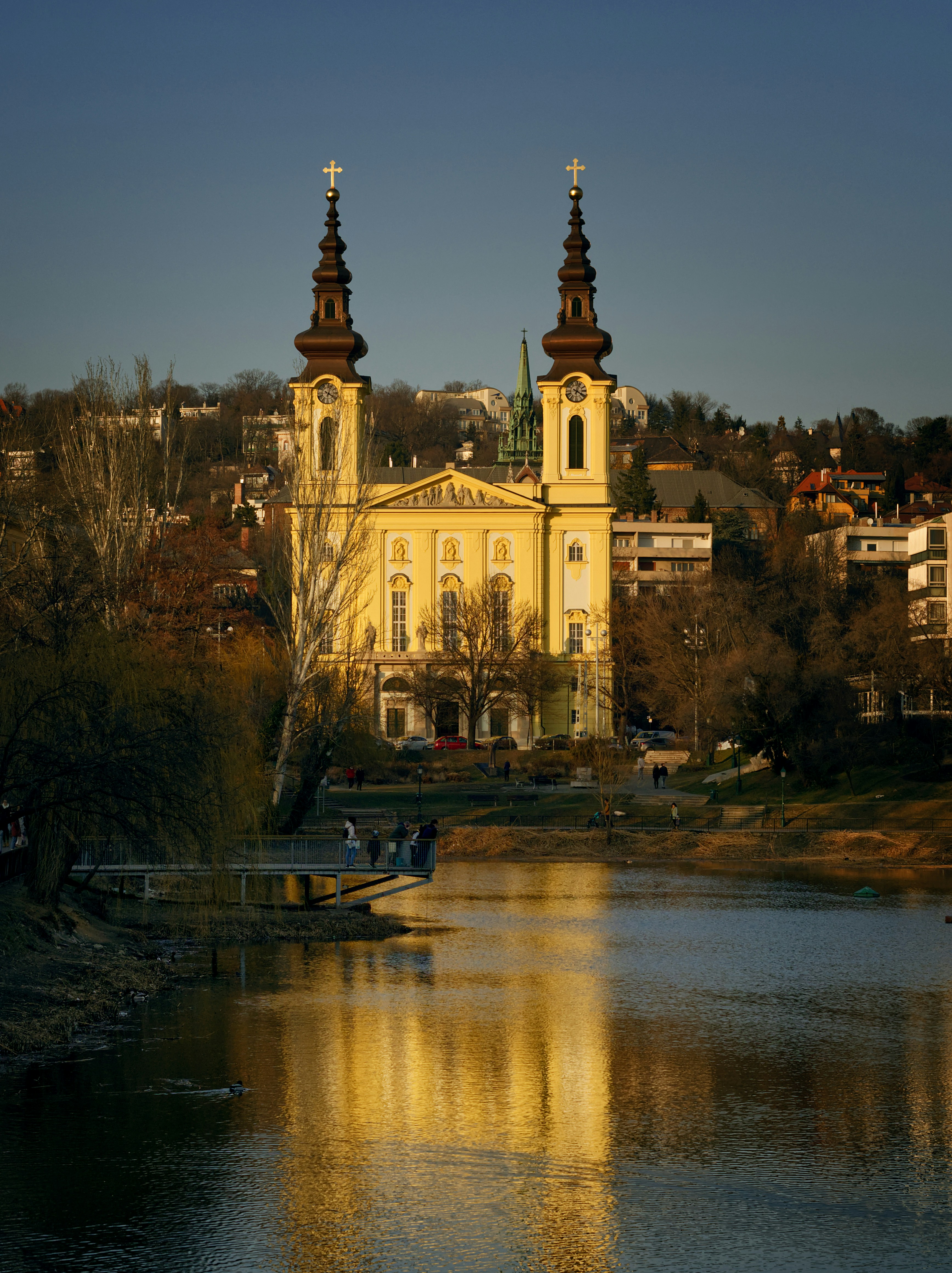 Twin-Towered Basilica at Golden Hour Over a Quiet River
