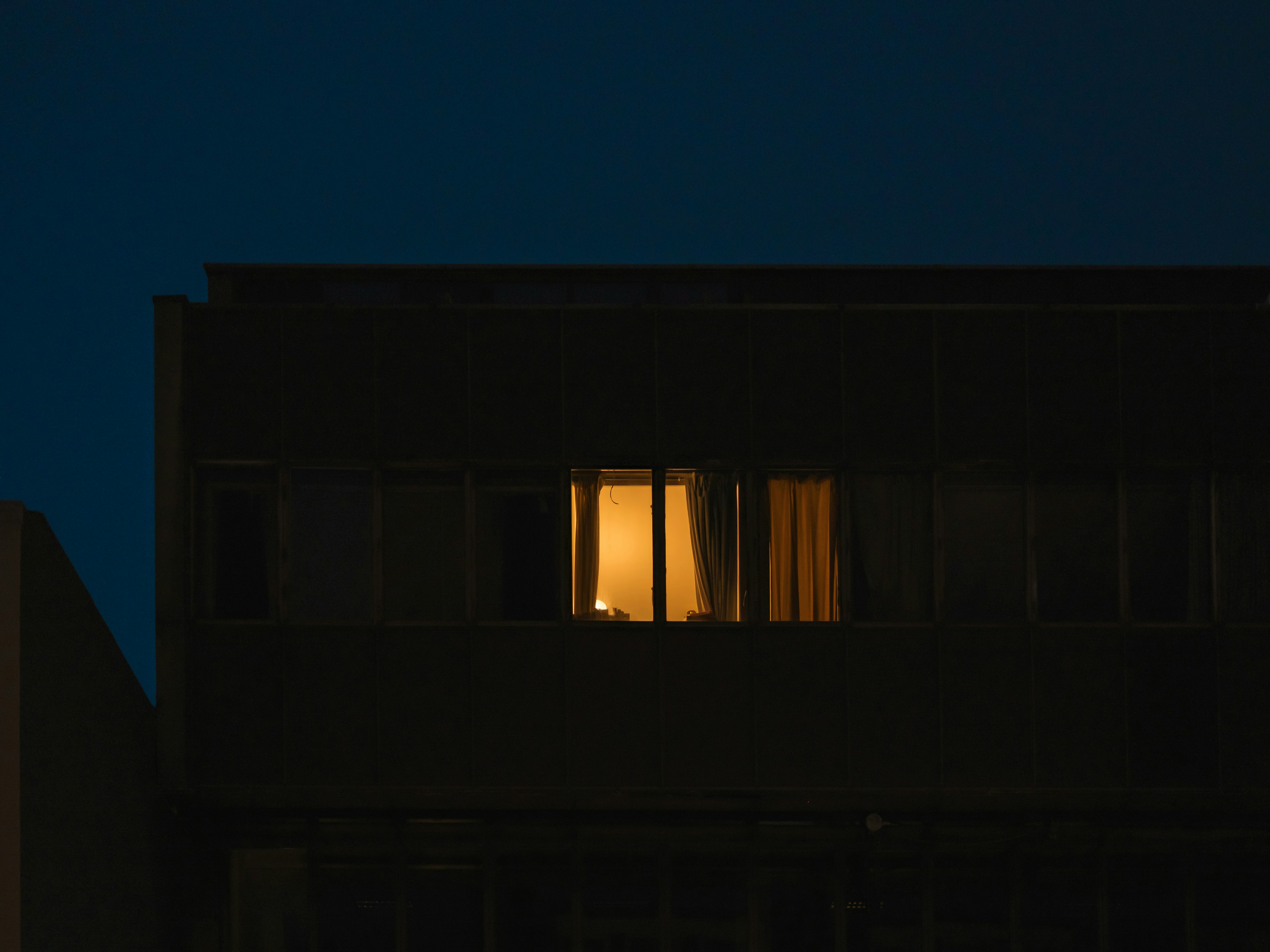 A building with a lit window at night photo – Free Urban Image on Unsplash