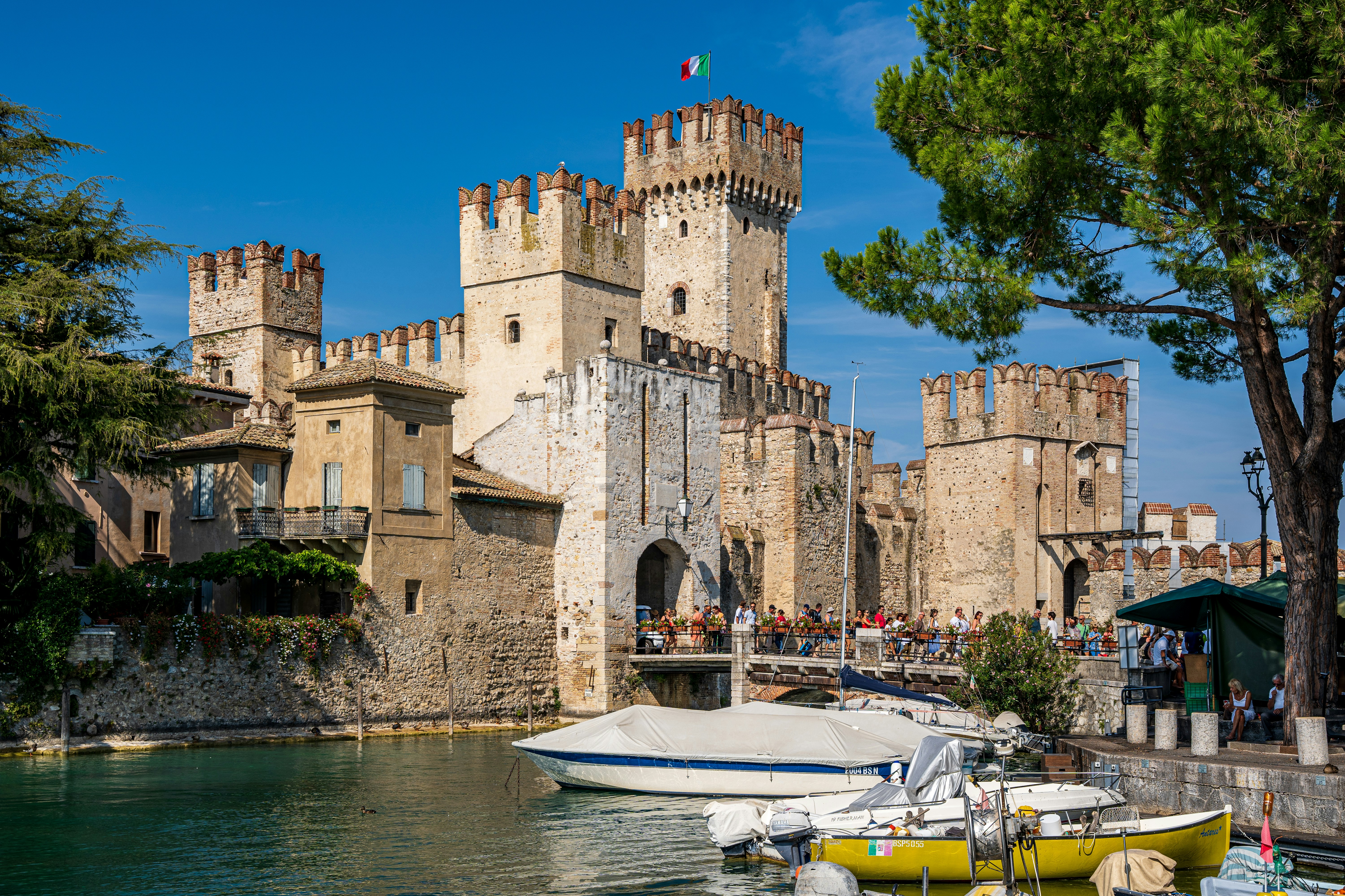 Castello Di Sirmione 🏰 | a boat is docked in front of a castle