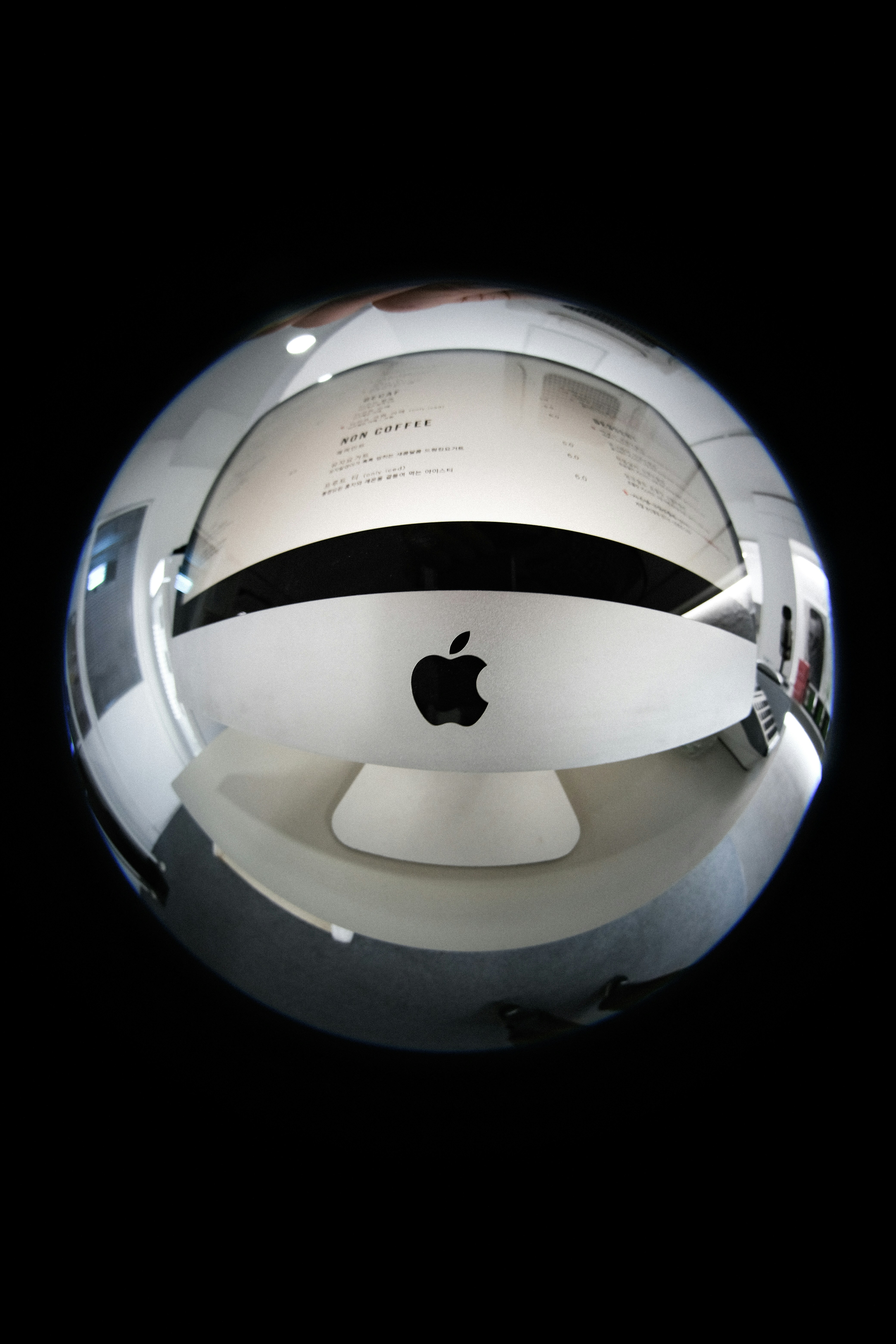 A sleek Apple iMac stands prominently against a dark backdrop, showcasing its minimalist design and modern aesthetic.