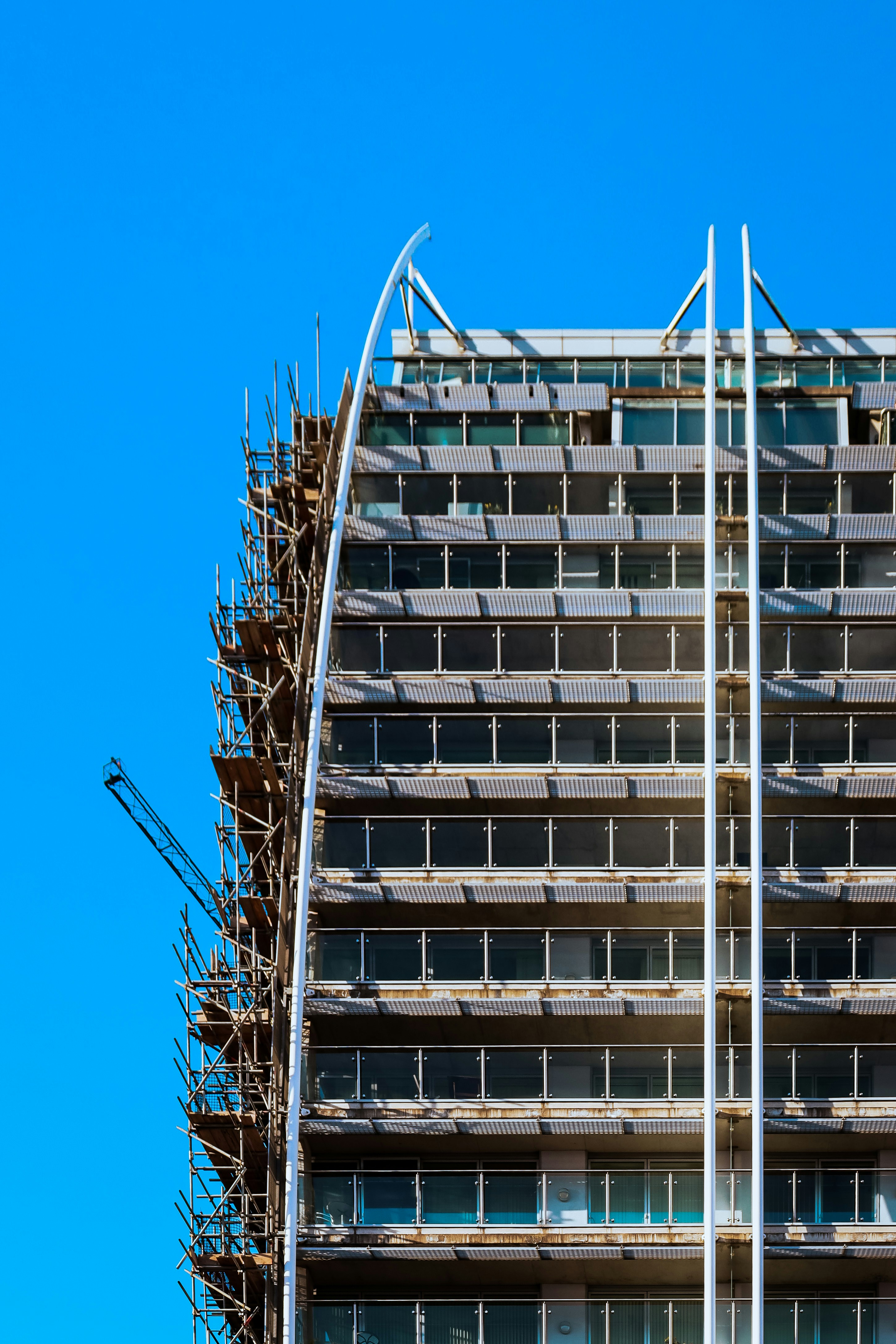 Arc of Construction: Exposed Steel and Glass Rising Against a Clear Sky