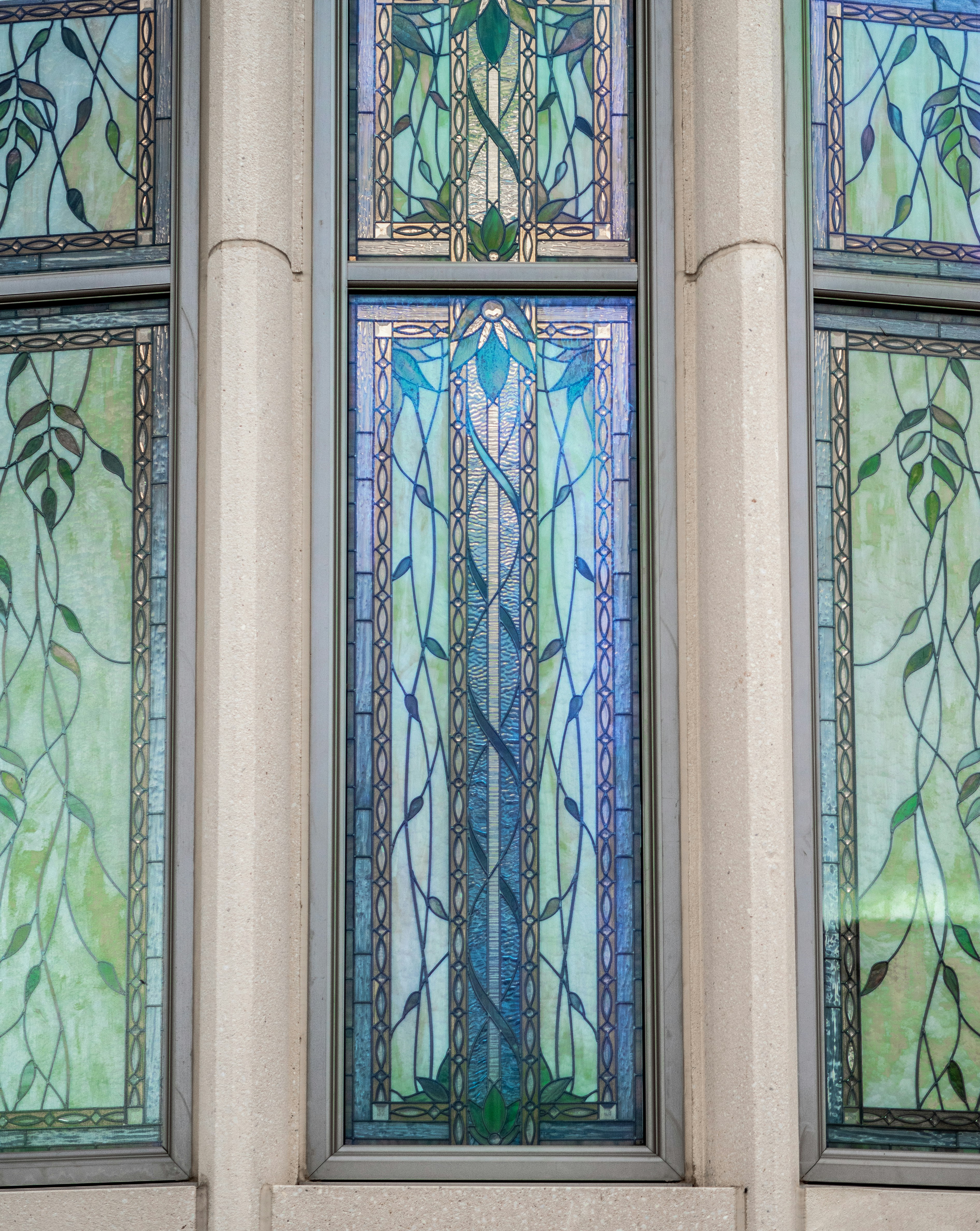 Intricate stained glass windows featuring floral motifs and vibrant colors, showcasing the beauty of craftsmanship in architectural design.