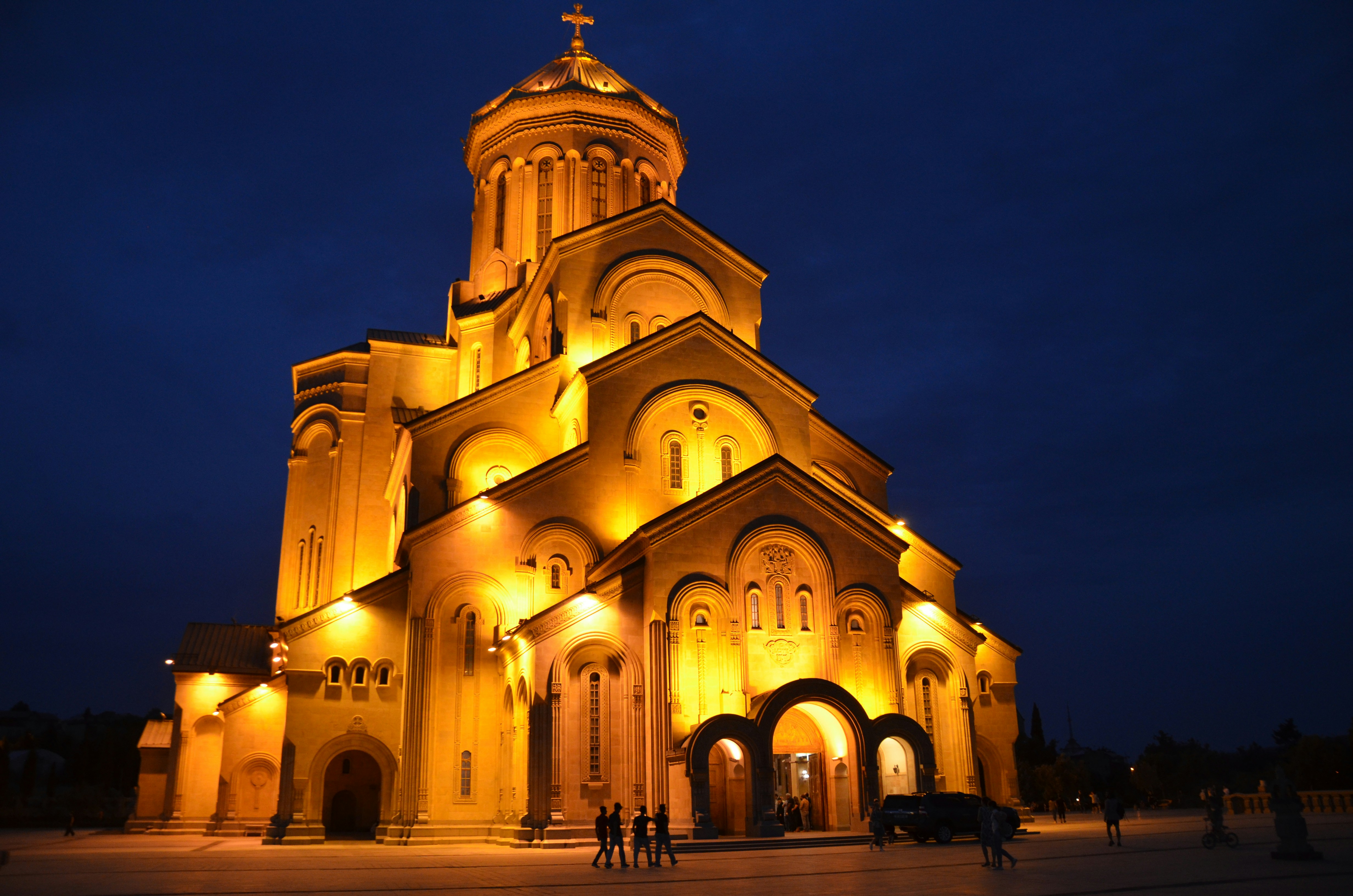 A church lit up at night with people standing outside photo – Free ...