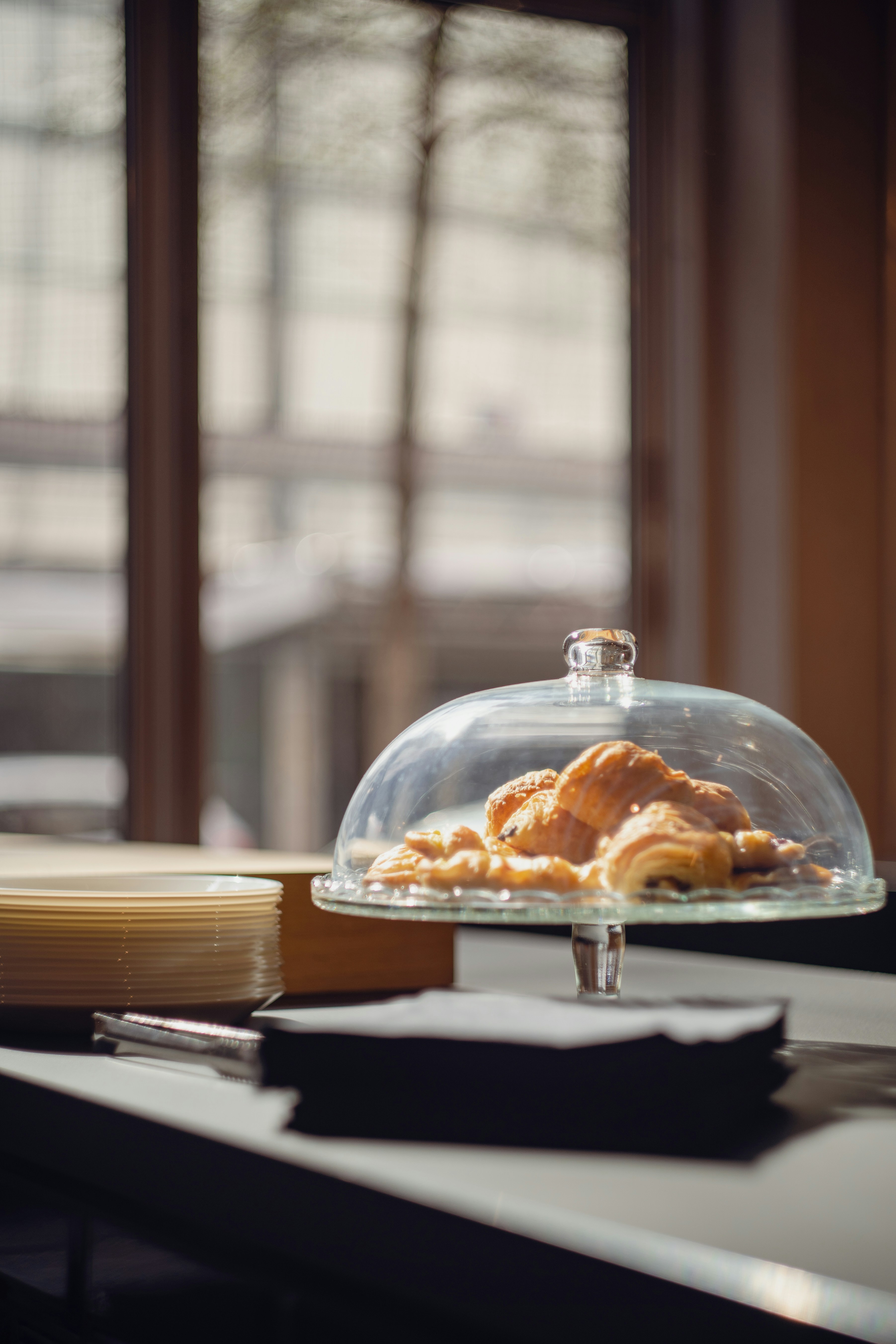 Under the Glass Dome: Croissant in Soft Café Light