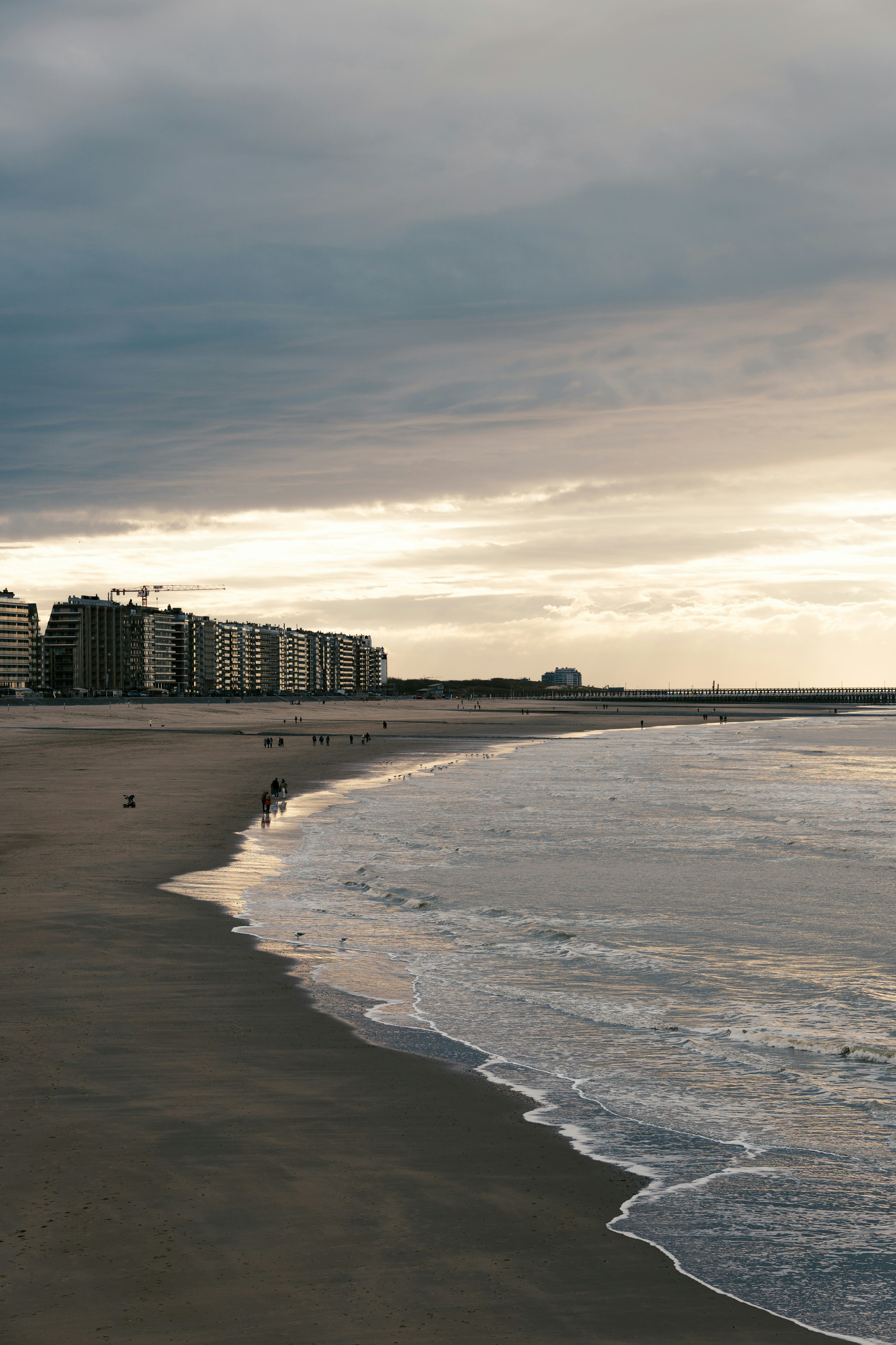 A view of a beach with buildings in the background photo – Free Sea ...