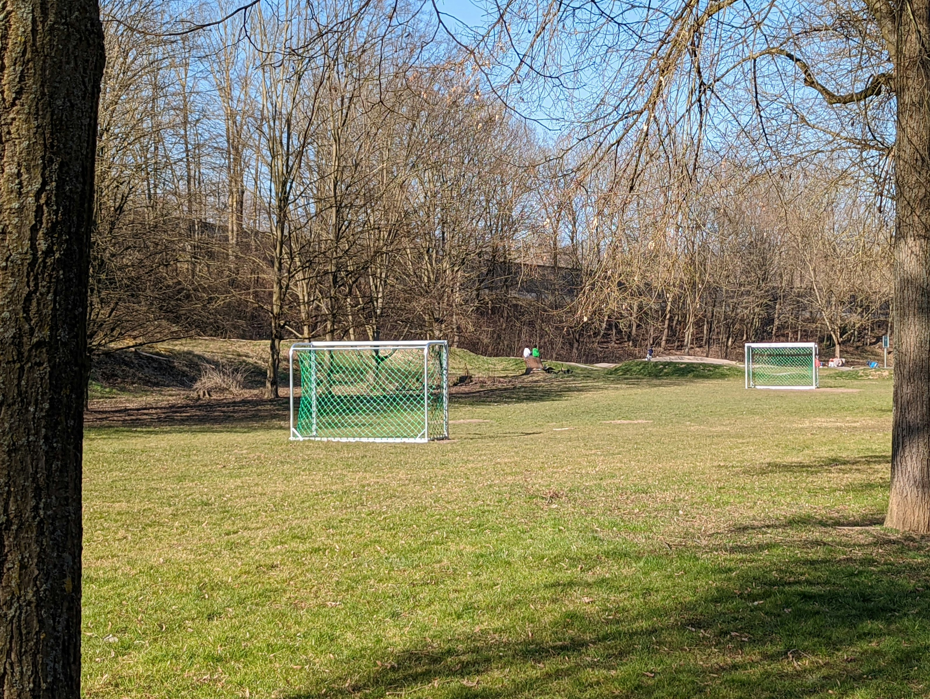 Sportsfield in early spring | a group of people playing soccer in a field