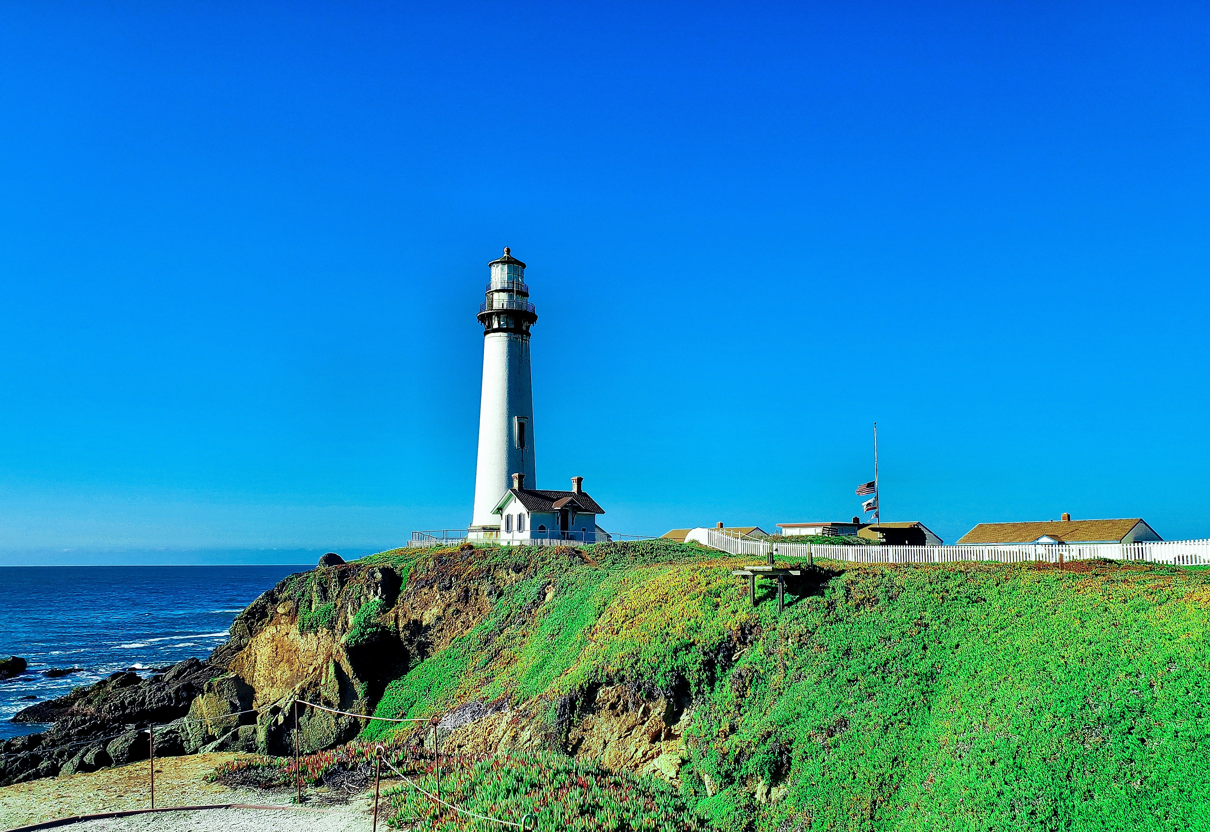 Cerulean Sky Over Emerald Cliffs: The Lone Lighthouse