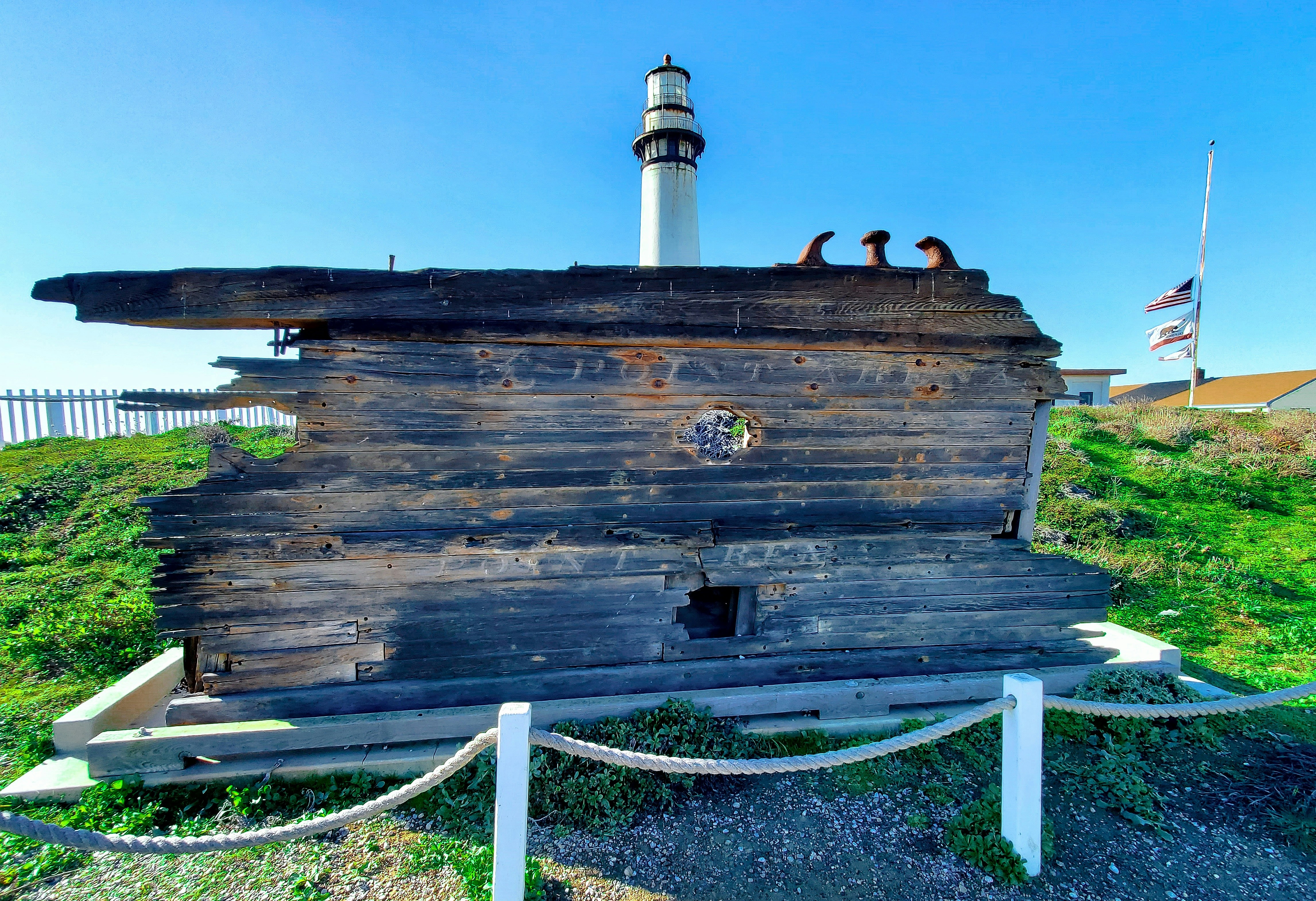 Weathered Sailor’s Log: A Charred Hull Resting Under a Blue Sky