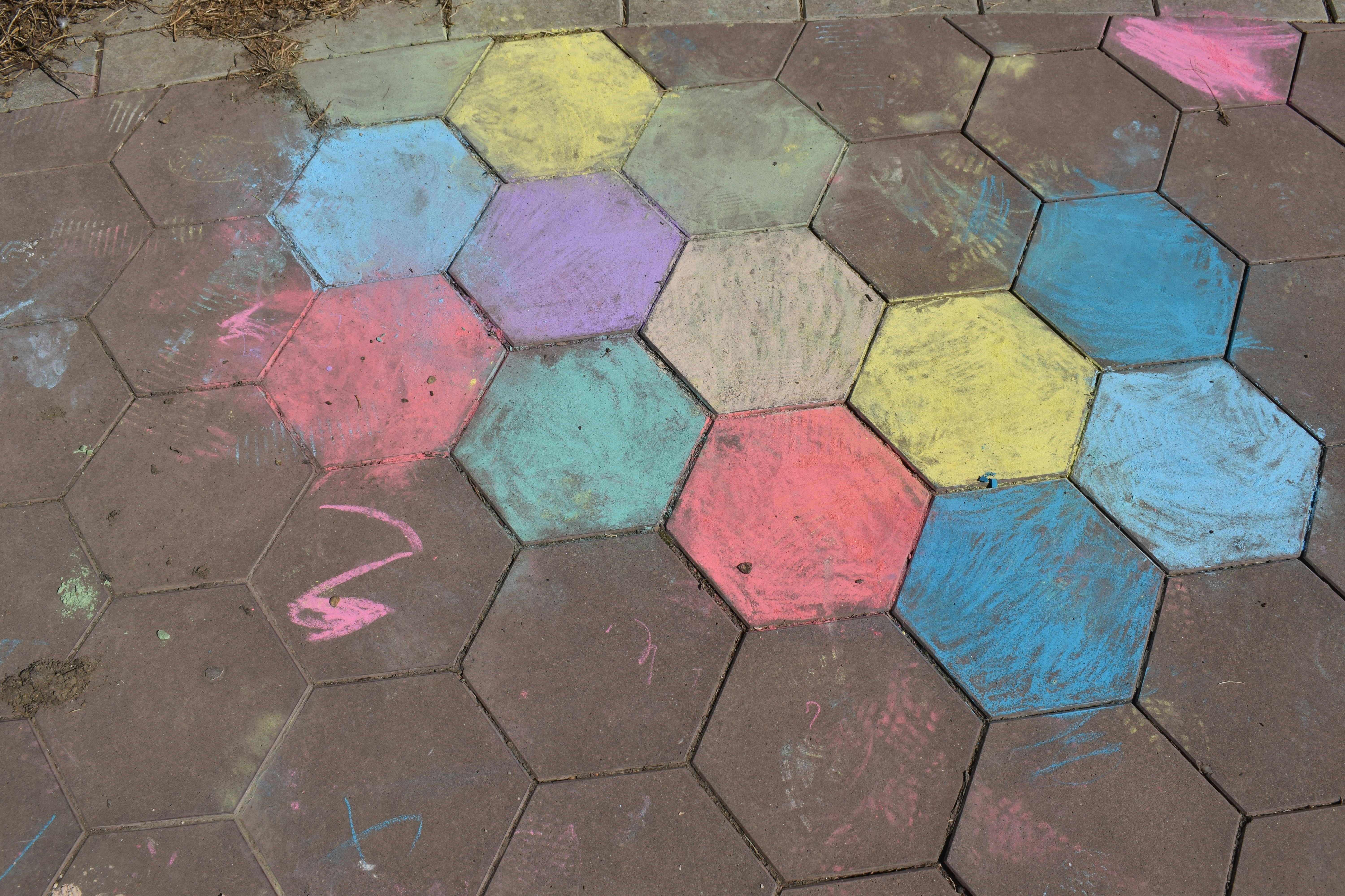 a sidewalk that has a bunch of colored chalk on it