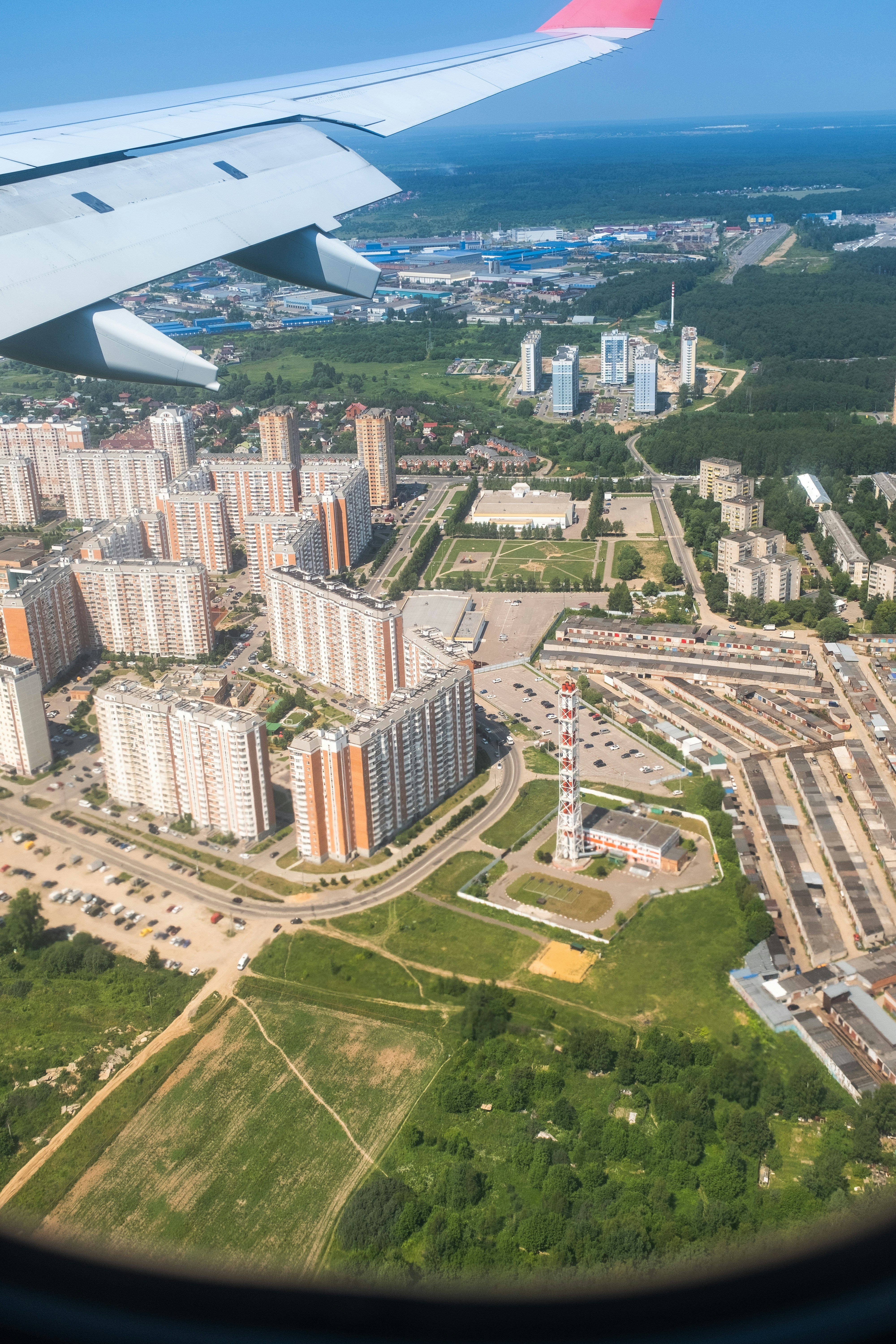Winged Overcity: Aerial Portrait of a Dense Apartment Grid Seen from a Window Seat