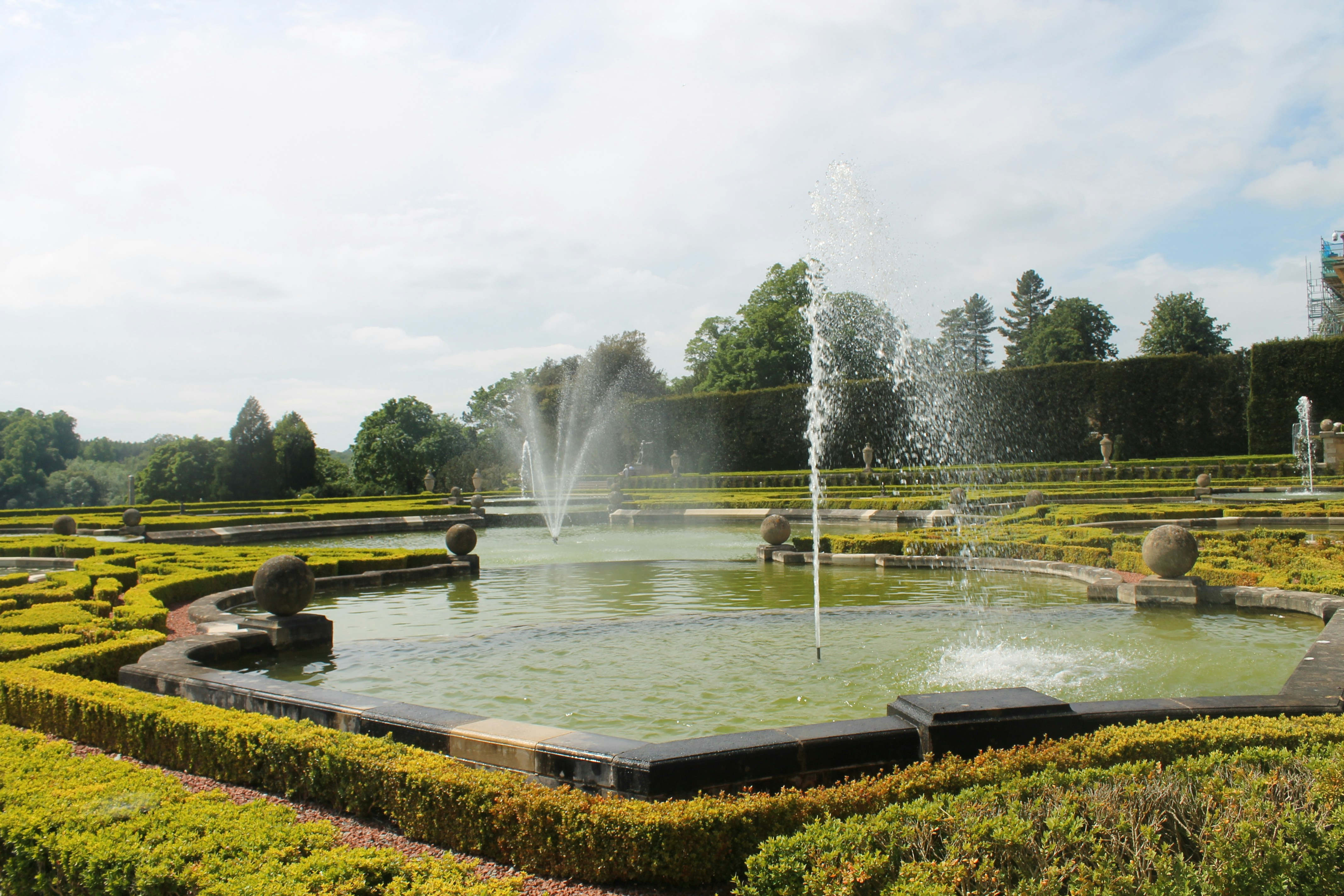 A water fountain surrounded by hedges and trees photo – Free Green ...
