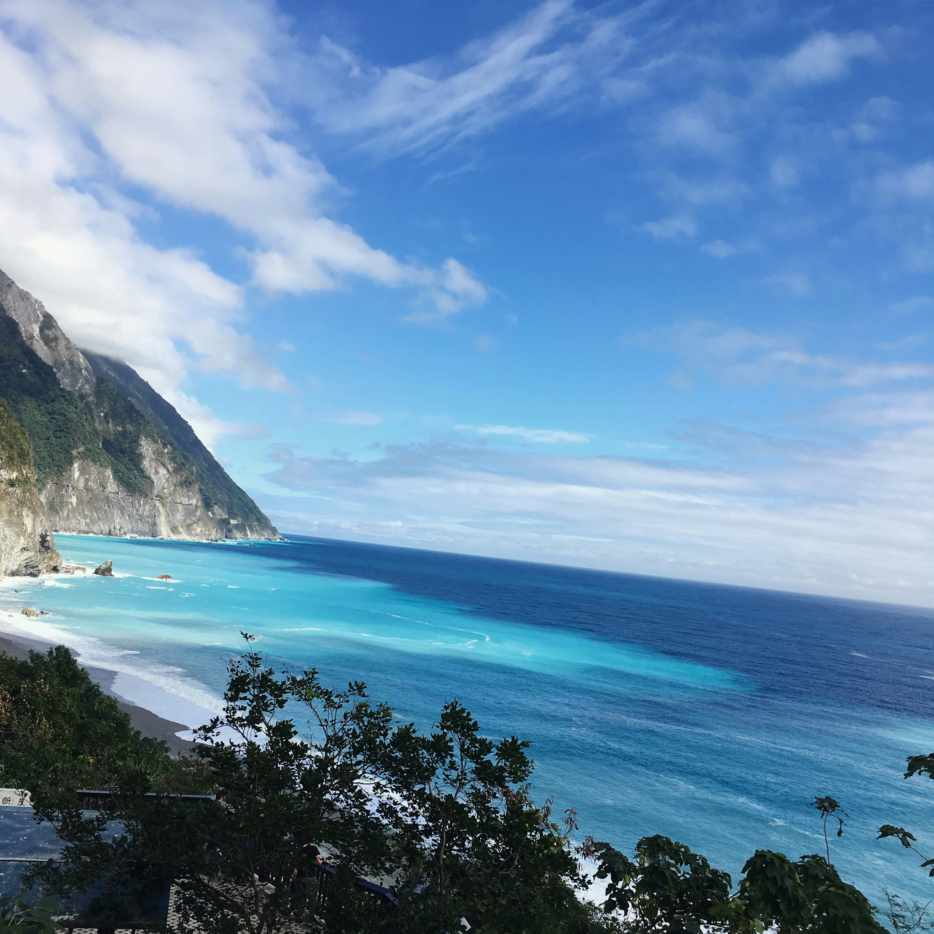 Vibrant turquoise waters meet rugged cliffs under a bright sky, capturing the essence of coastal tranquility.
