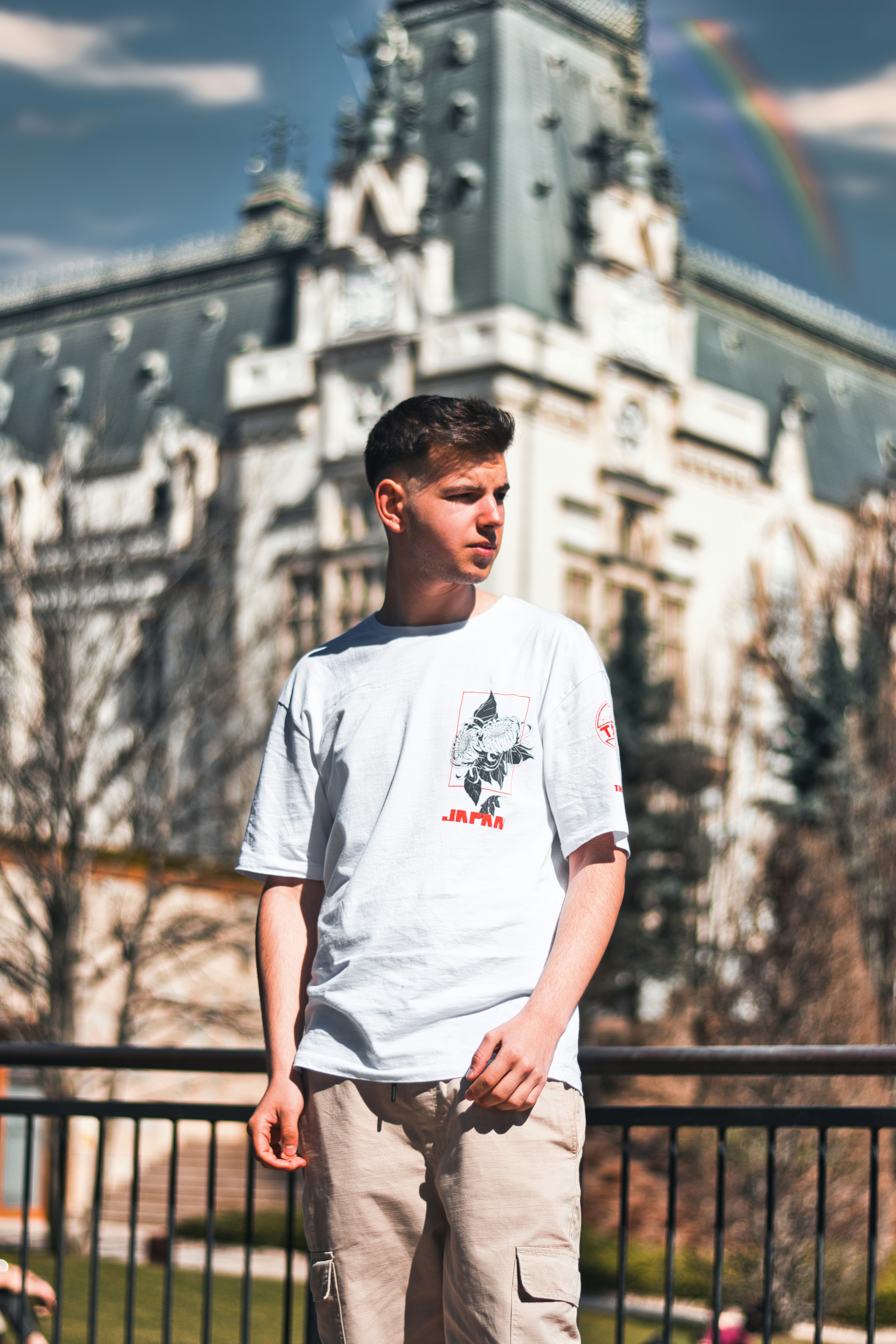 Portrait in Front of a Historic Facade with a Faint Rainbow