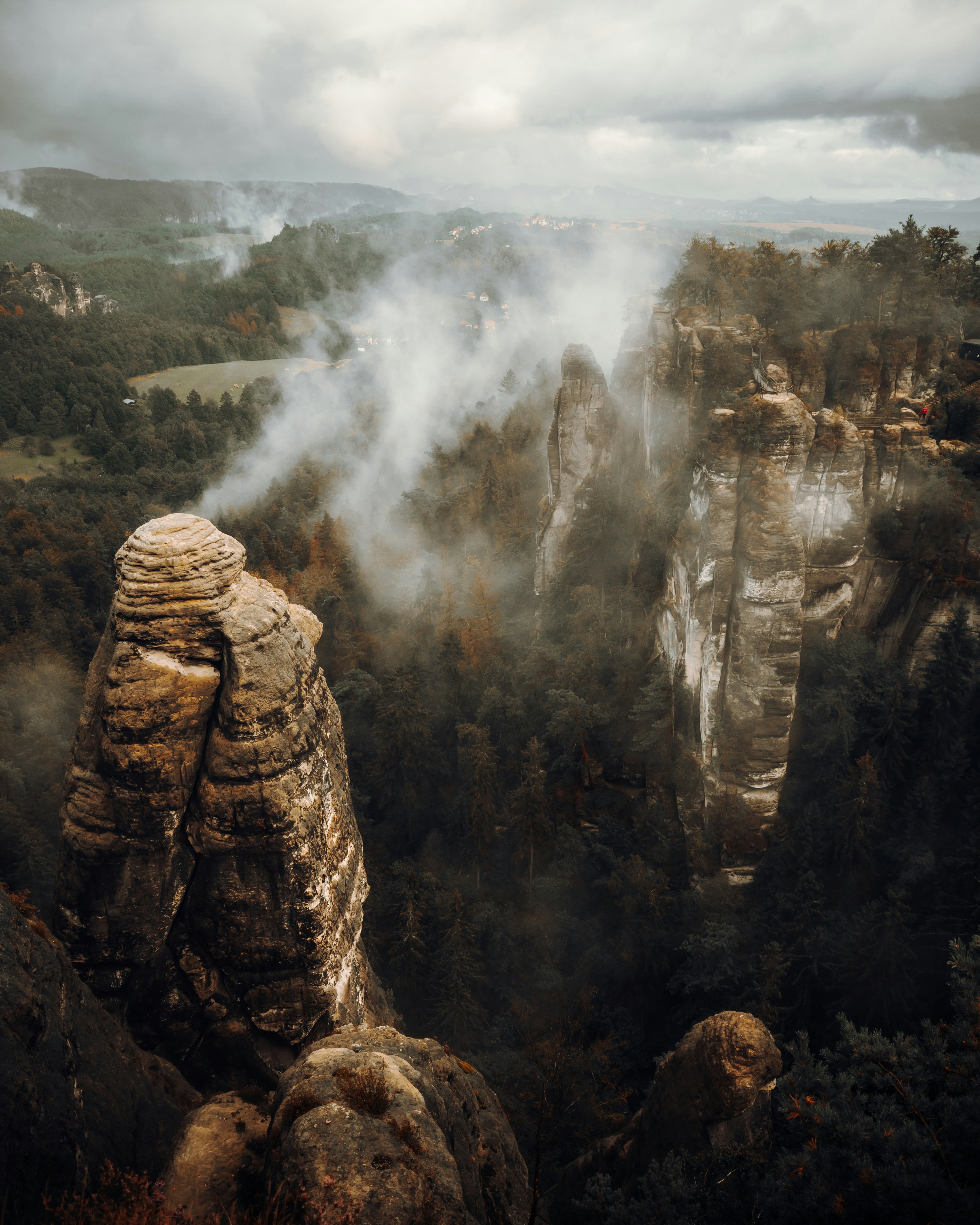 Stone Sentinels Shrouded in Mist Over a Forest Gorge