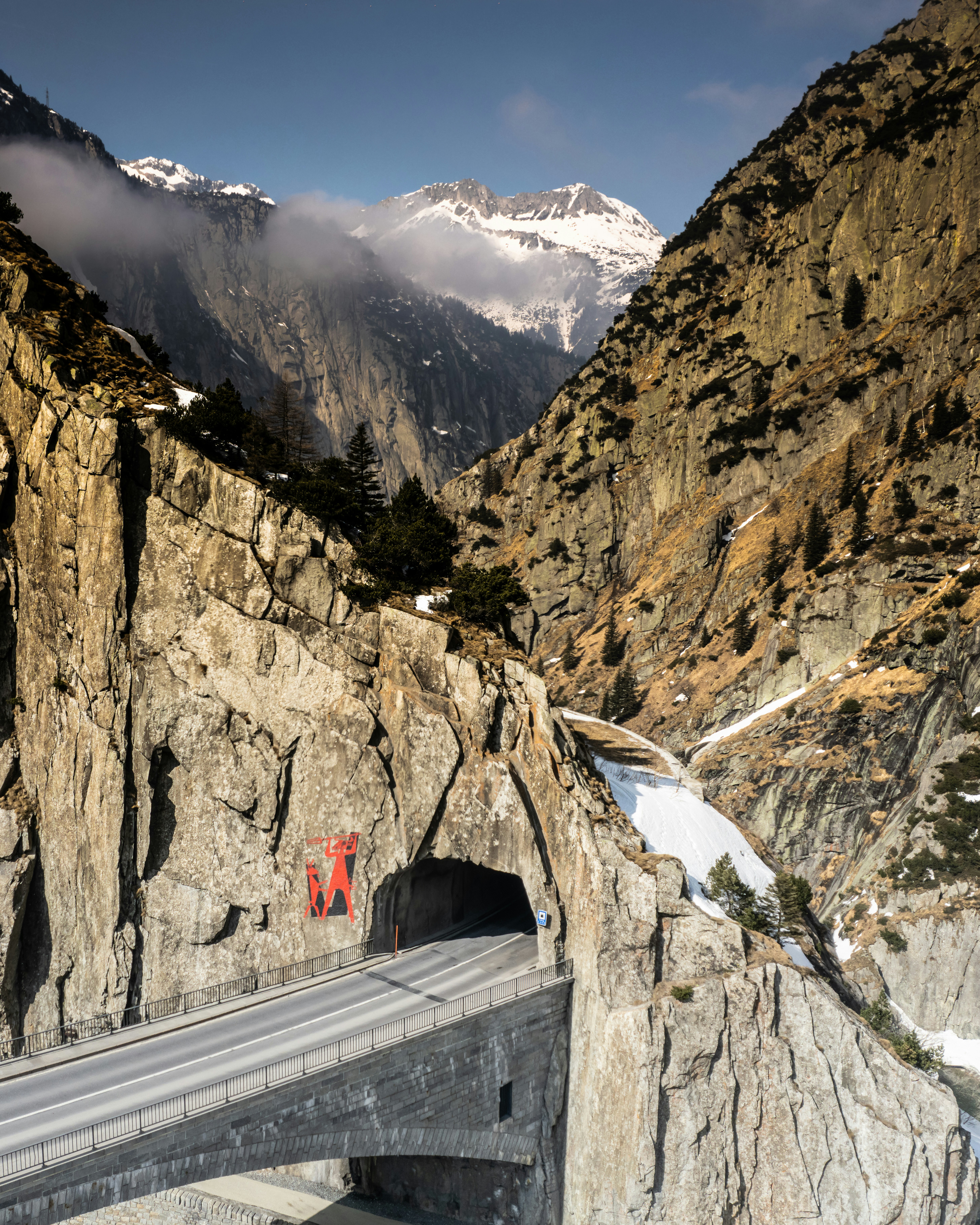 Alpine Corridor: The Bridge Piercing Granite Beneath Snow-Capped Peaks