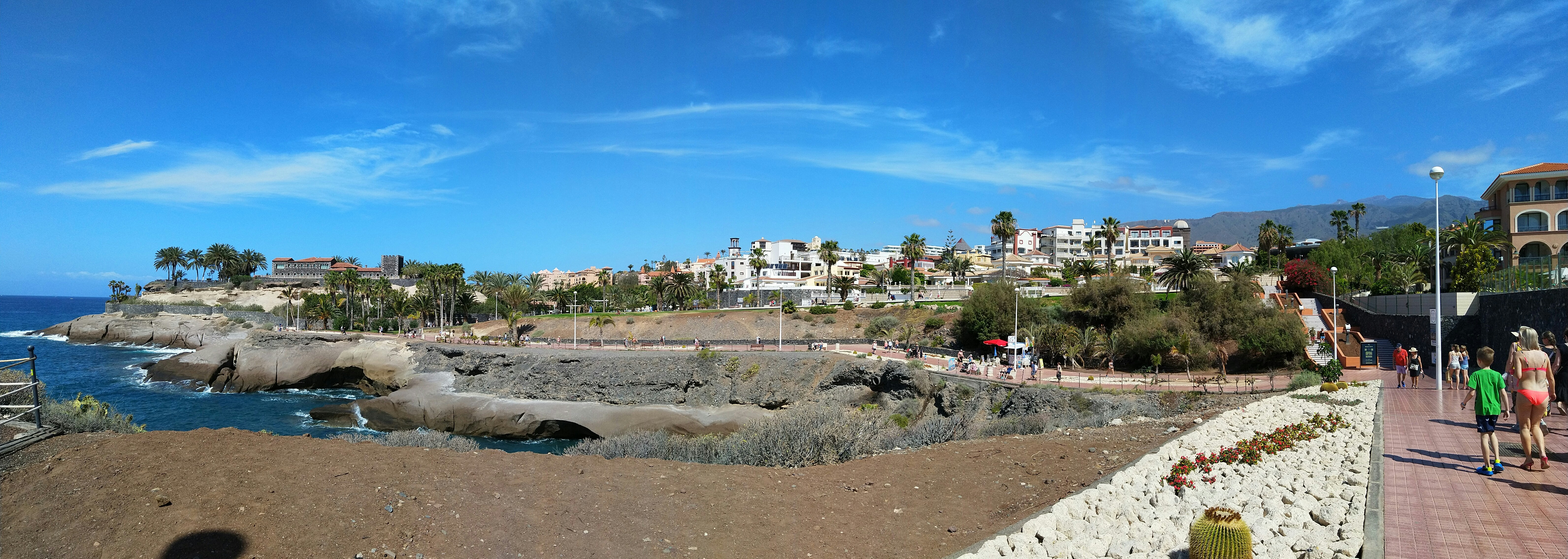 a group of people walking along a beach next to the ocean