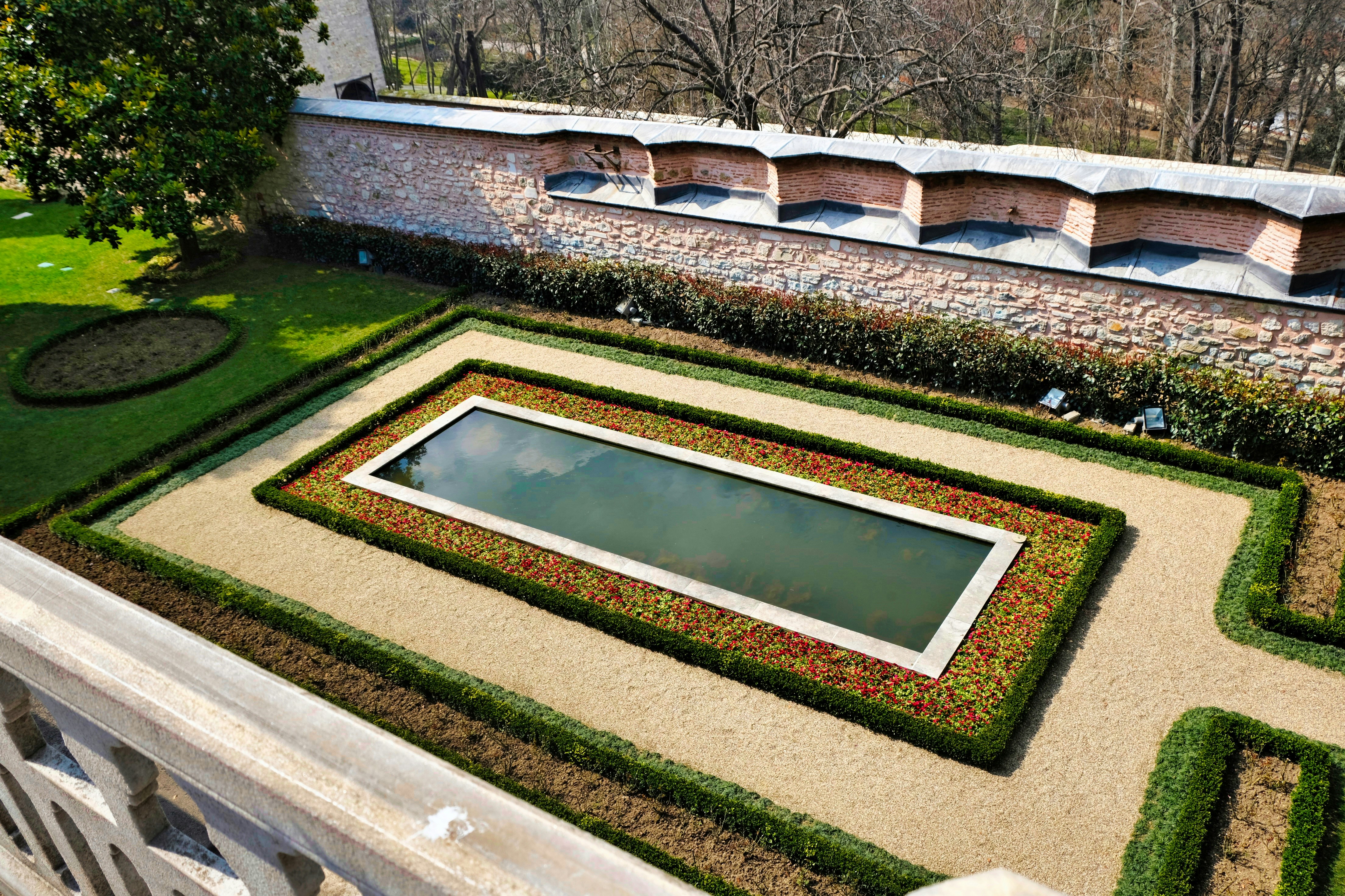 A garden with a pond surrounded by hedges photo – Free Garden Image on ...