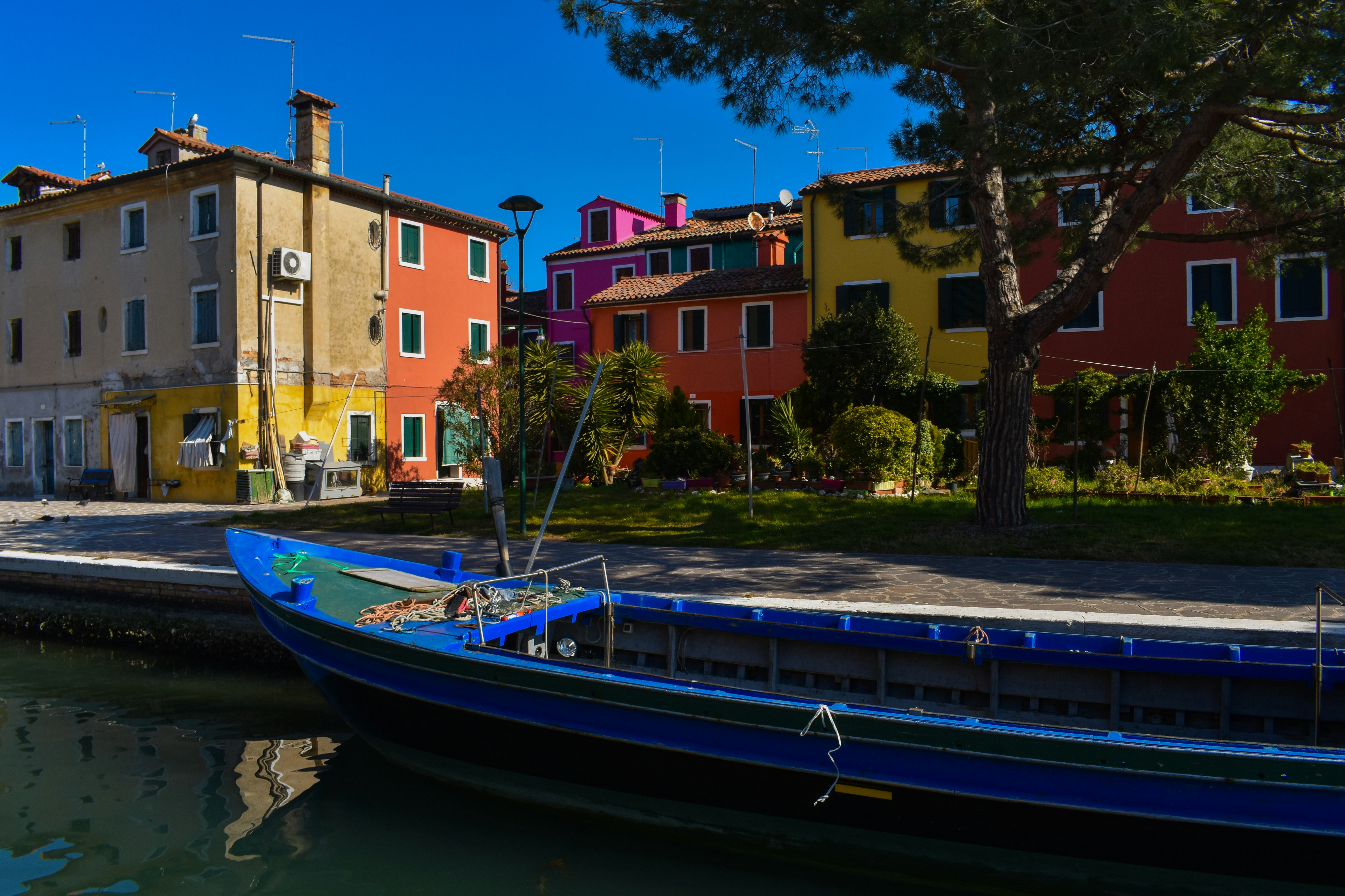 A row of houses next to a body of water photo – Free Italy Image on ...