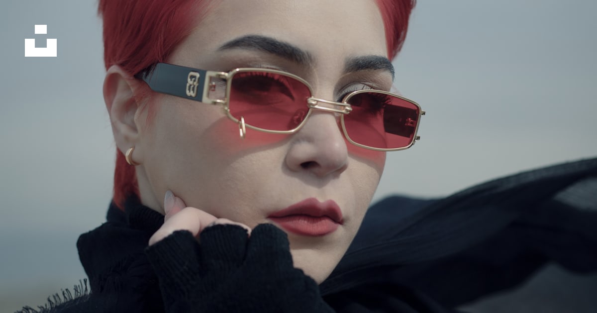 A Woman With Red Hair Wearing Sunglasses And A Black Jacket Photo